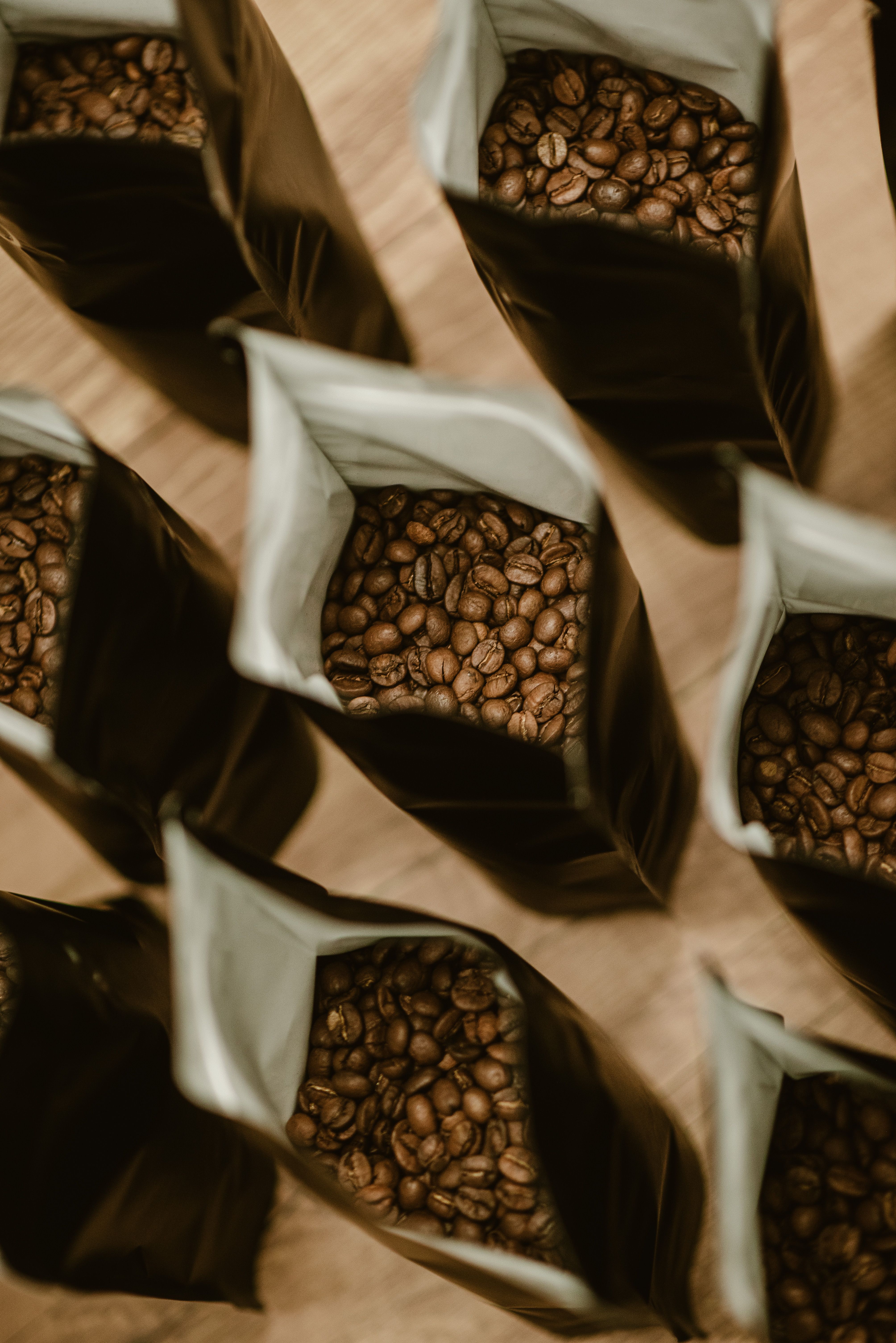 Coffee Beans in Spoon over Coffee Bags · Free Stock Photo