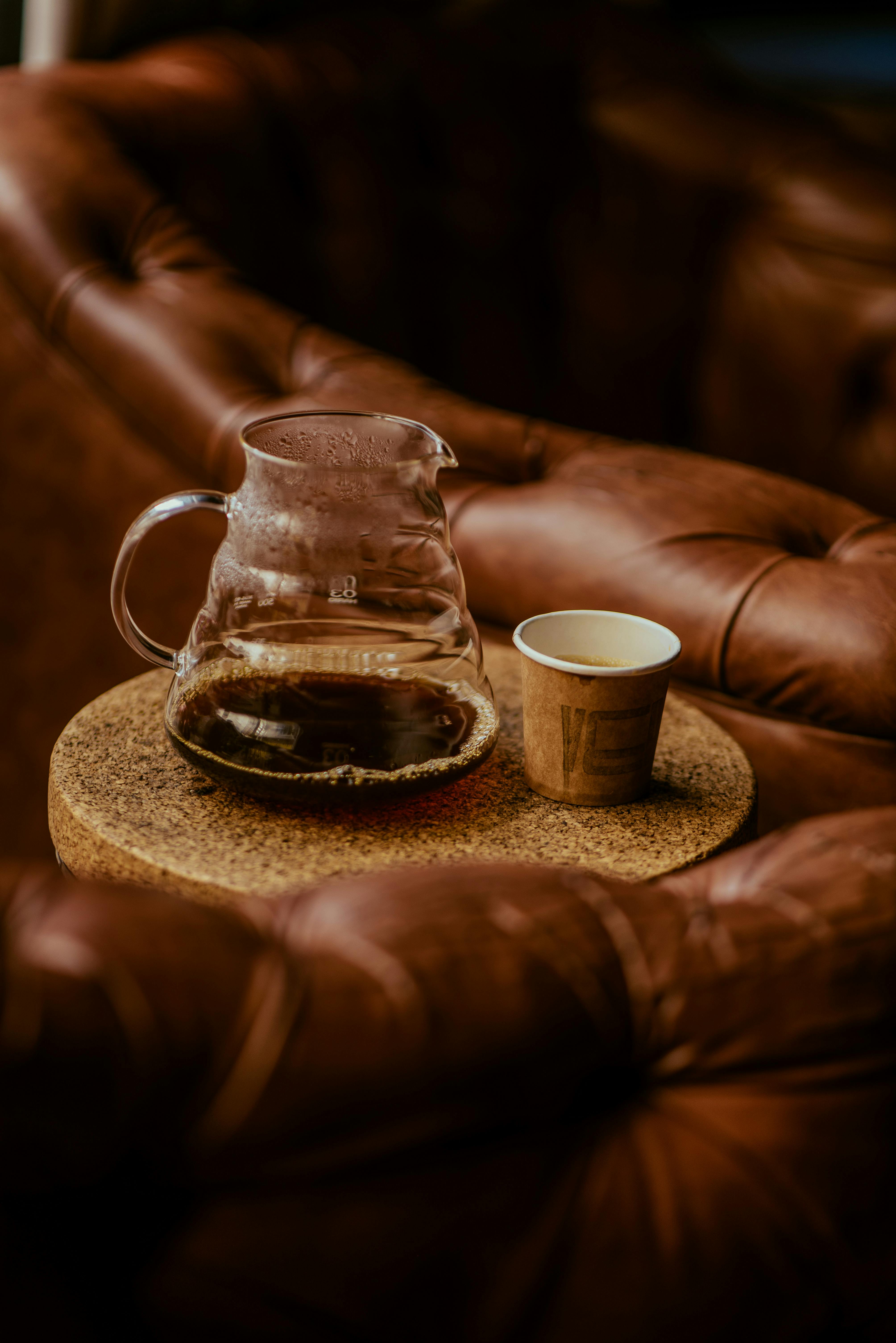 Disposable Cup and Glass Jug of Coffee on Table · Free Stock Photo