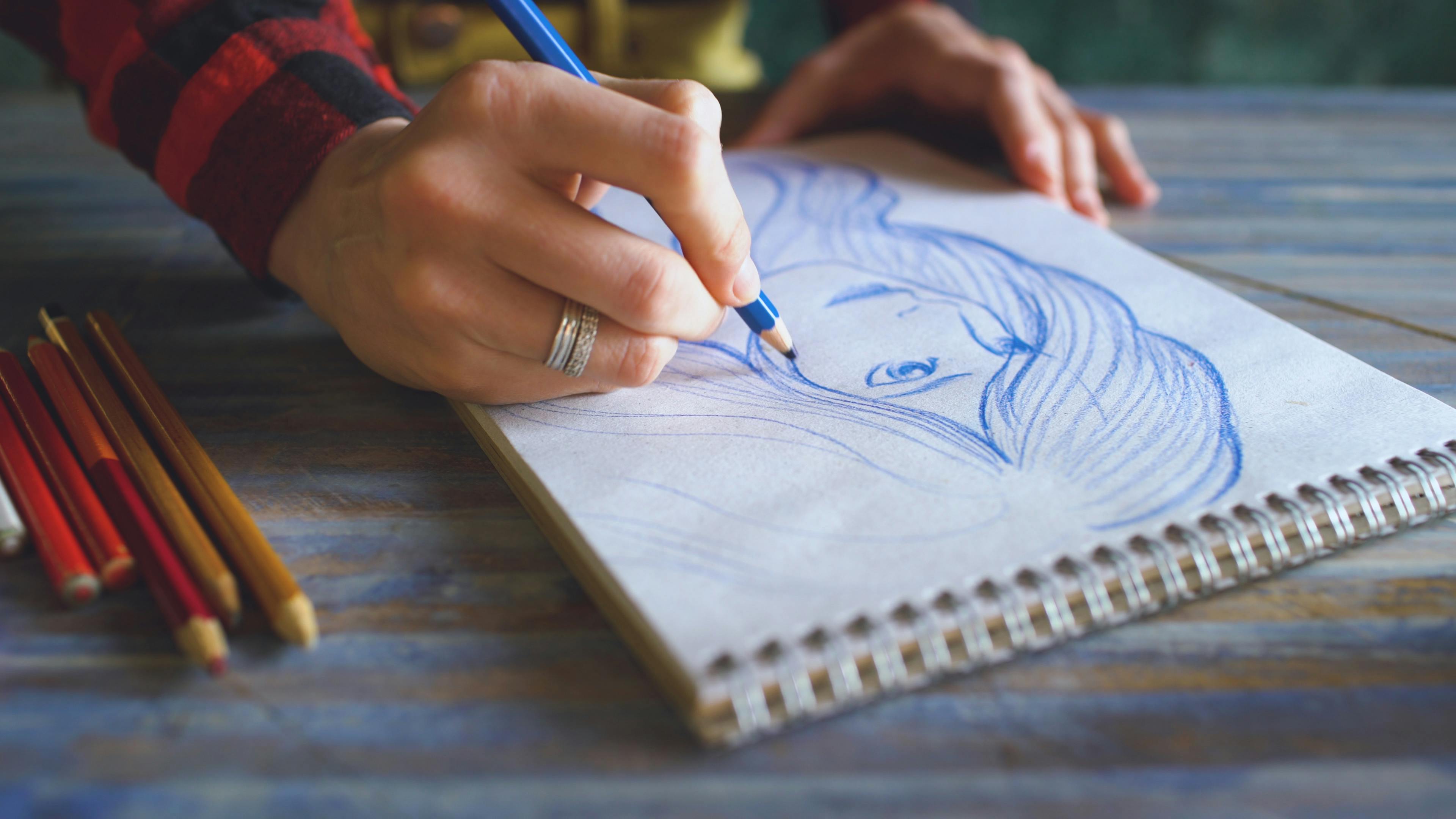 Close-up of a Person Drawing in a Sketchpad · Free Stock Photo