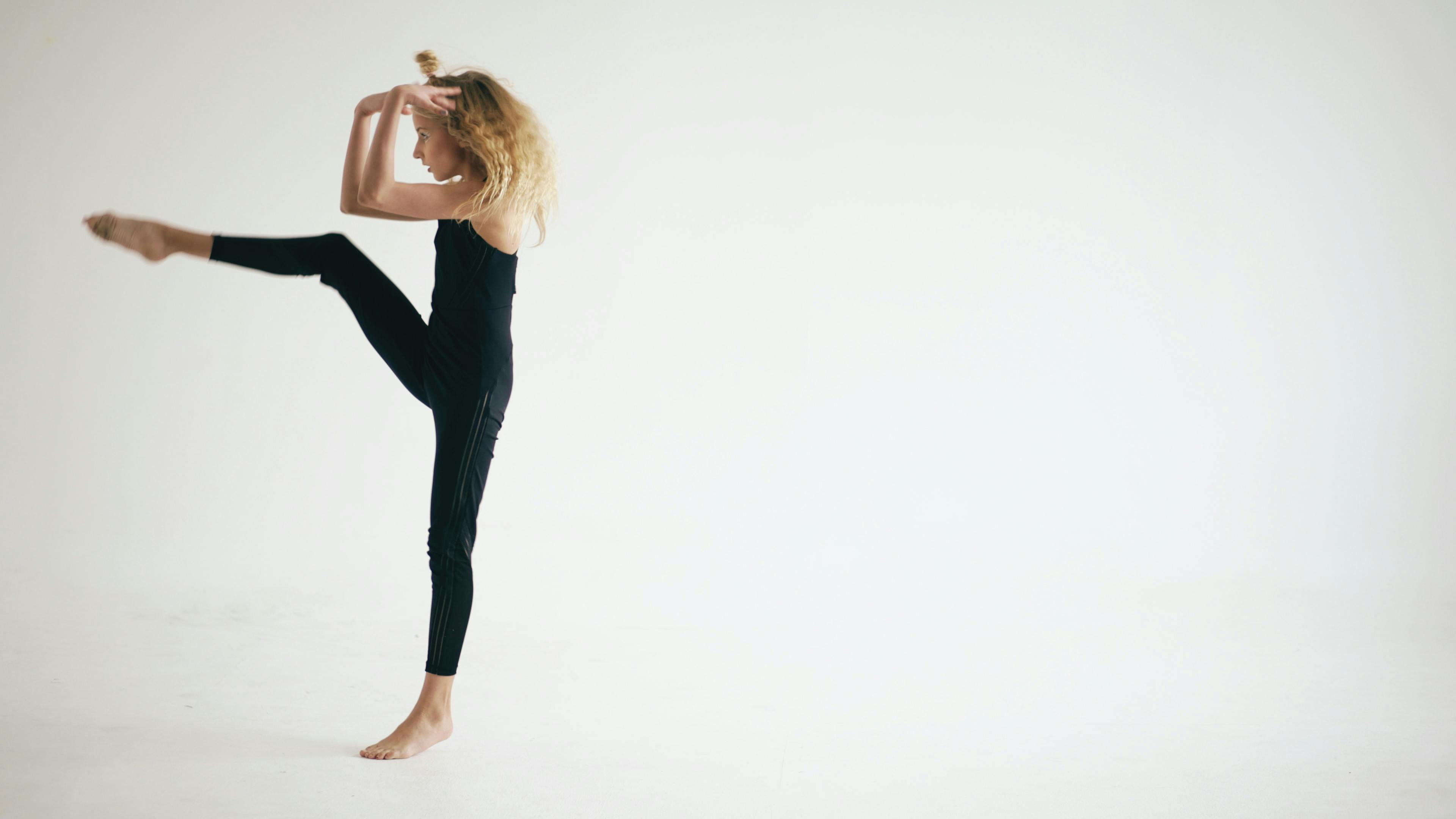A woman in black leggings doing a kick · Free Stock Photo