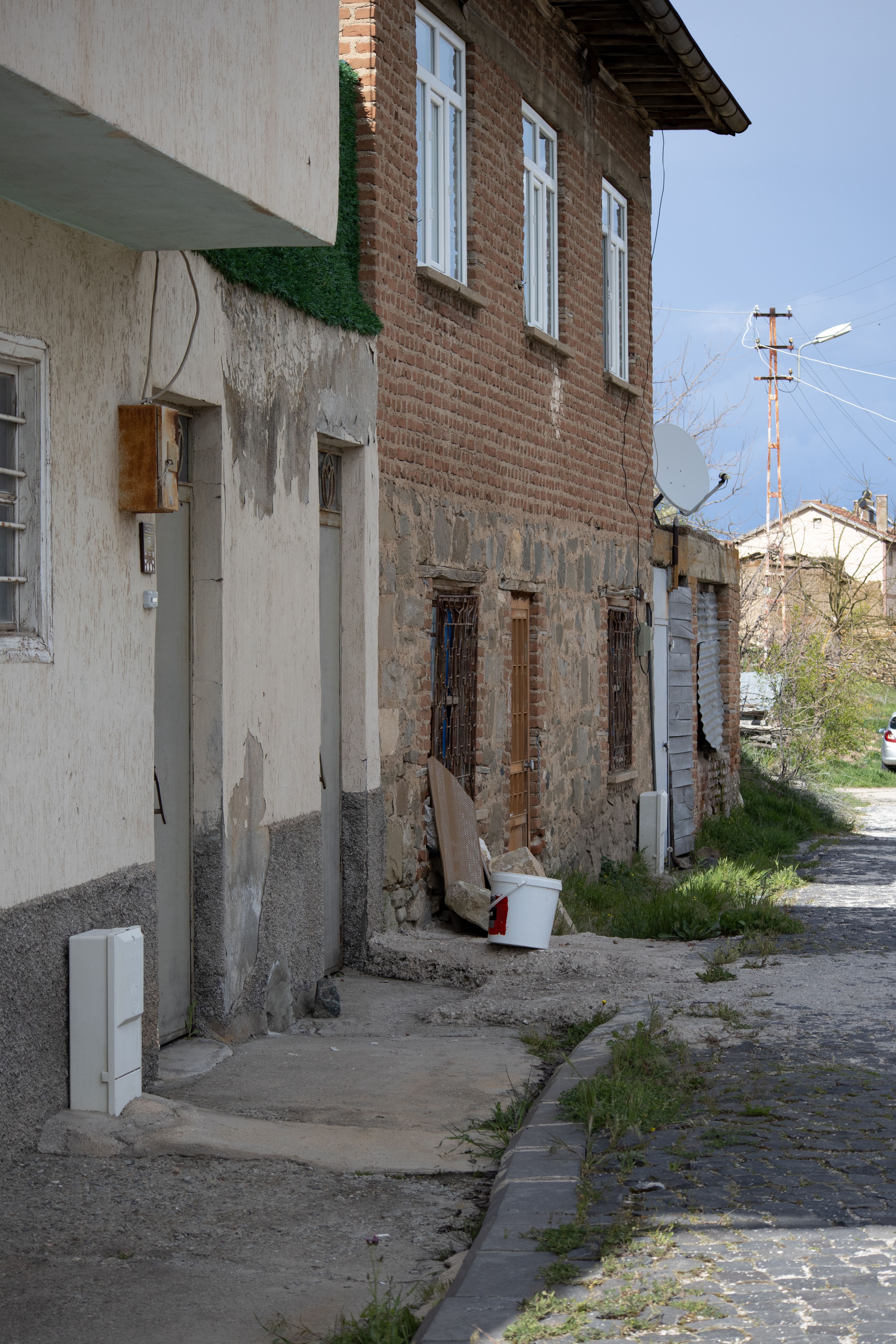 Rural Apartment Buildings next to Cobblestone Road · Free Stock Photo