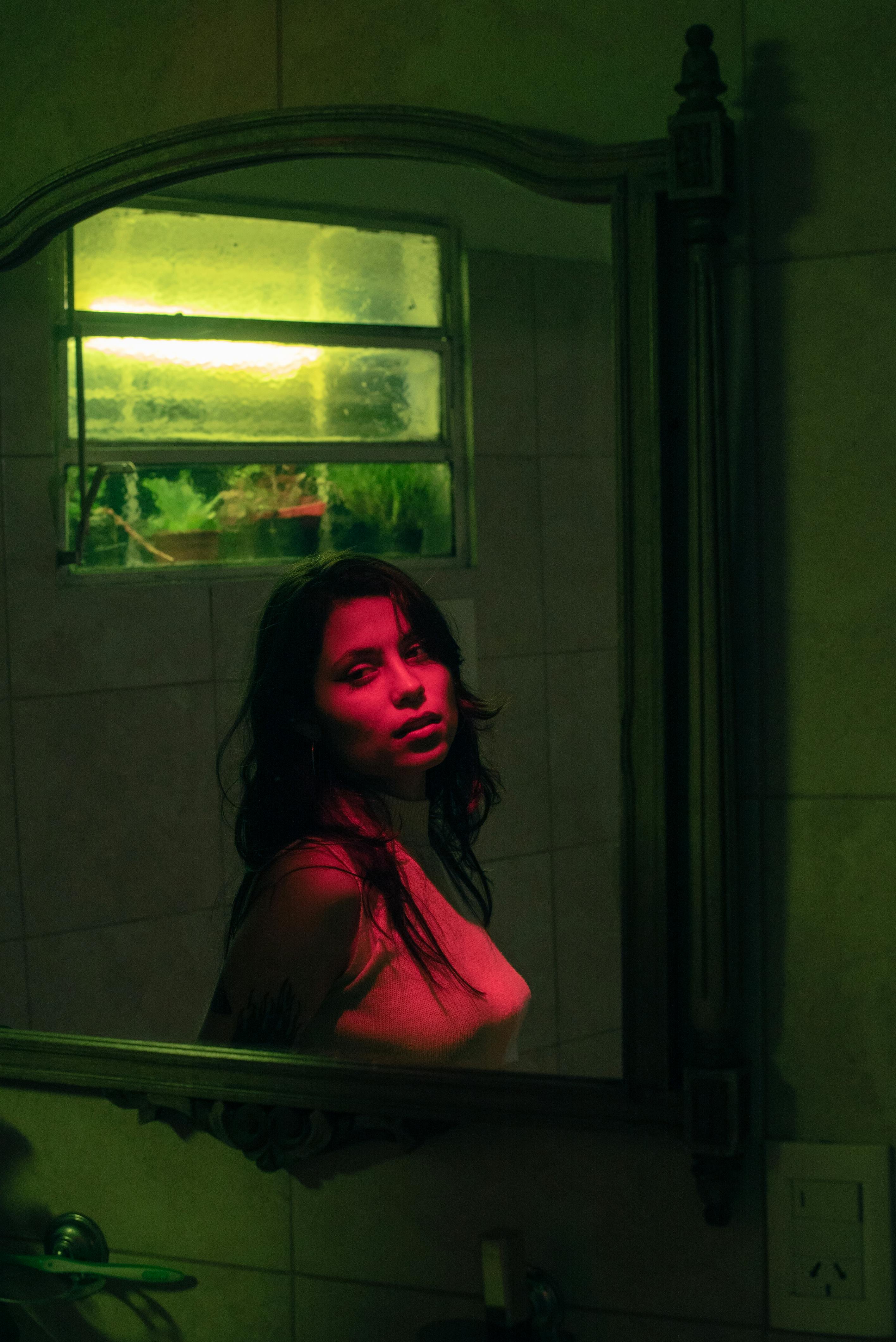 Reflection of Woman in Mirror in Red Light · Free Stock Photo