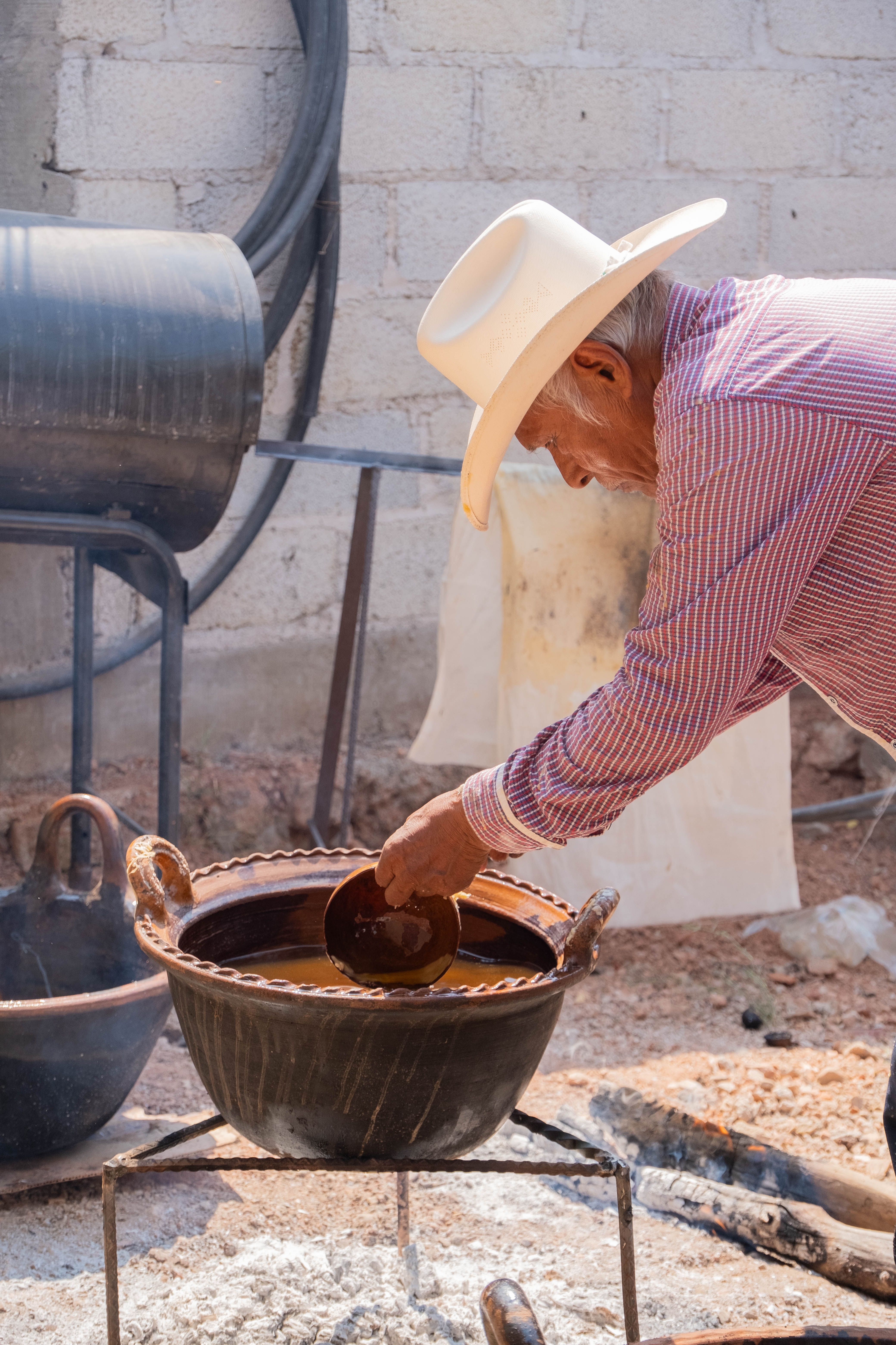 Senior Man Pouring Liquid into a Cauldron Standing Outdoors · Free ...
