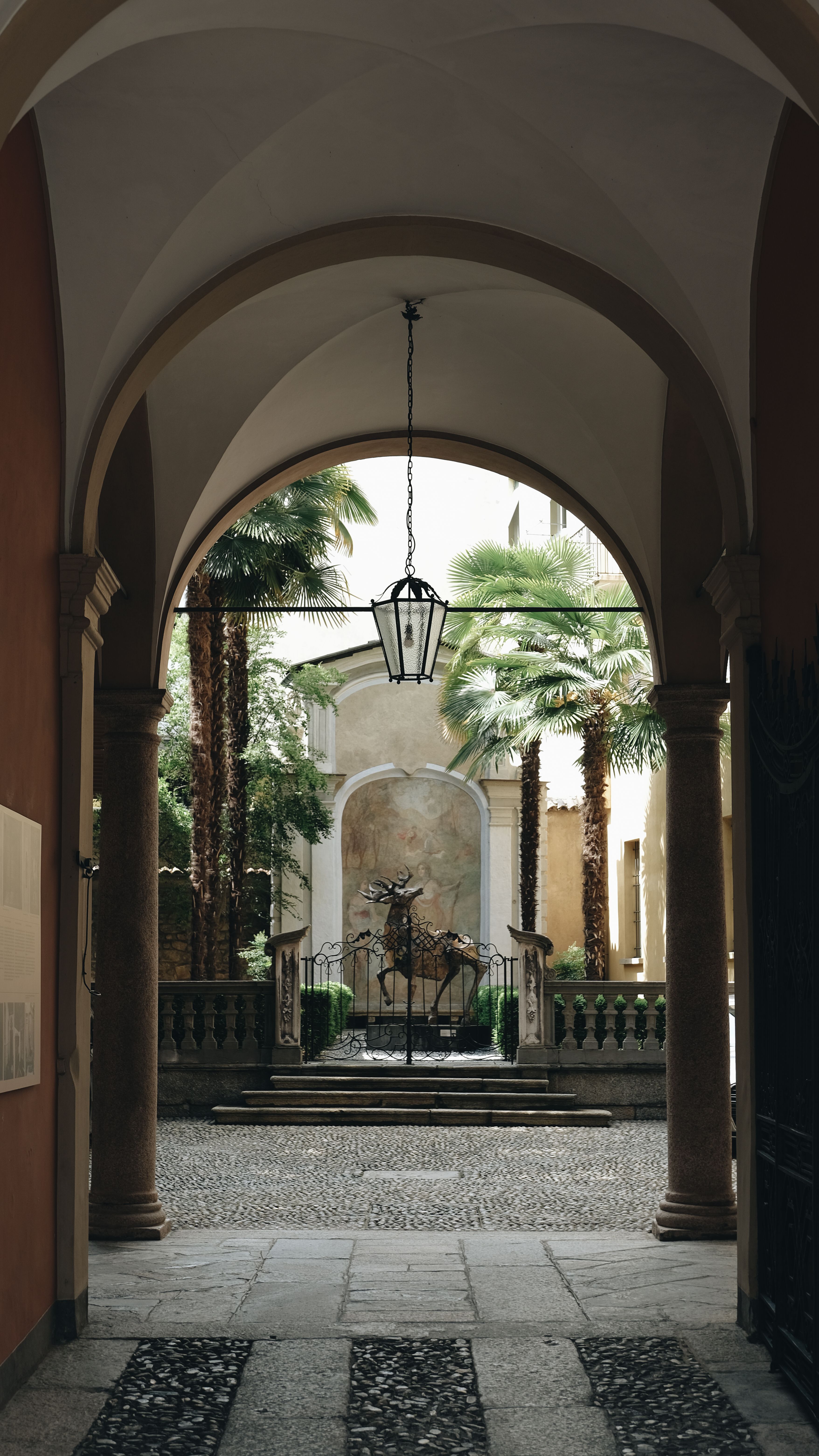 View of an Arch and a Courtyard with Palm Trees · Free Stock Photo