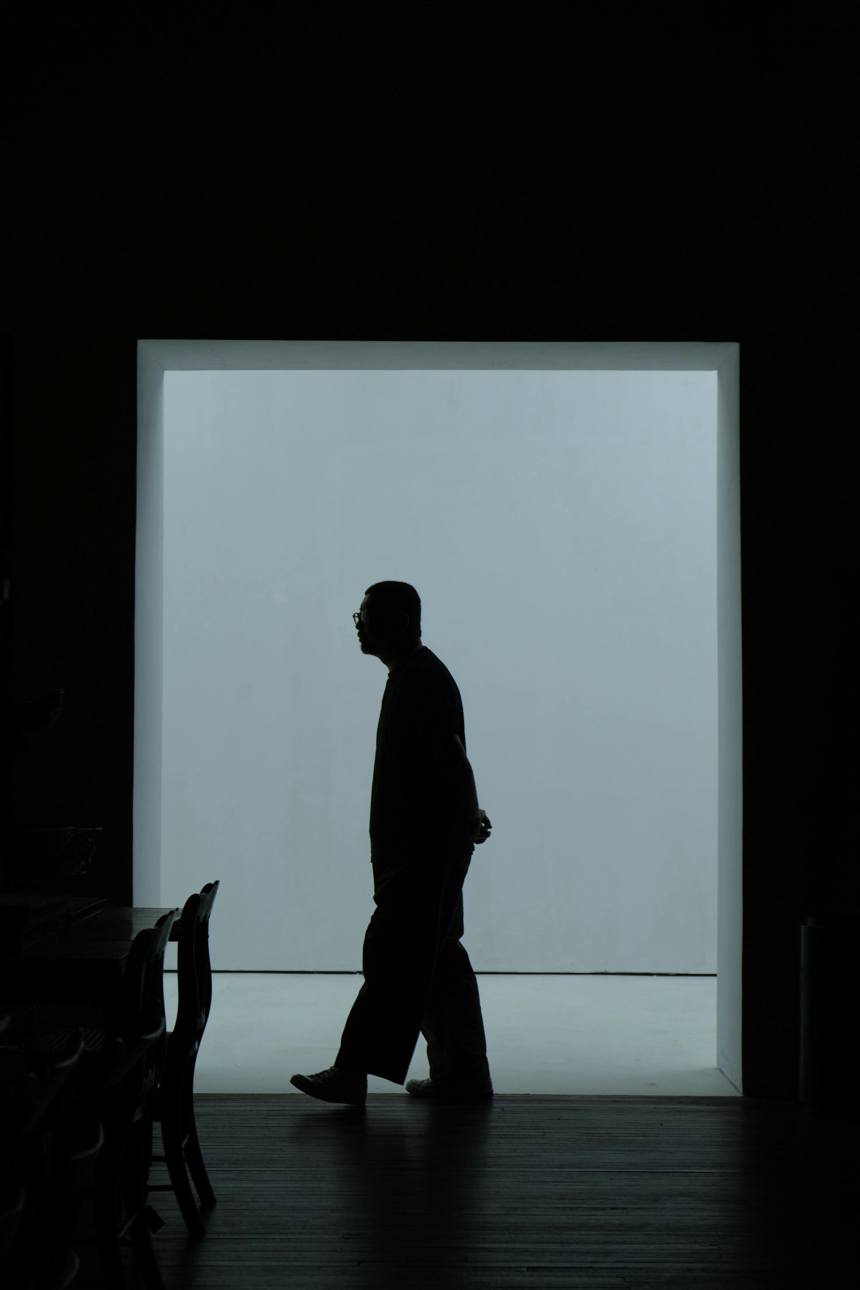 A man walks into a room with a light on · Free Stock Photo