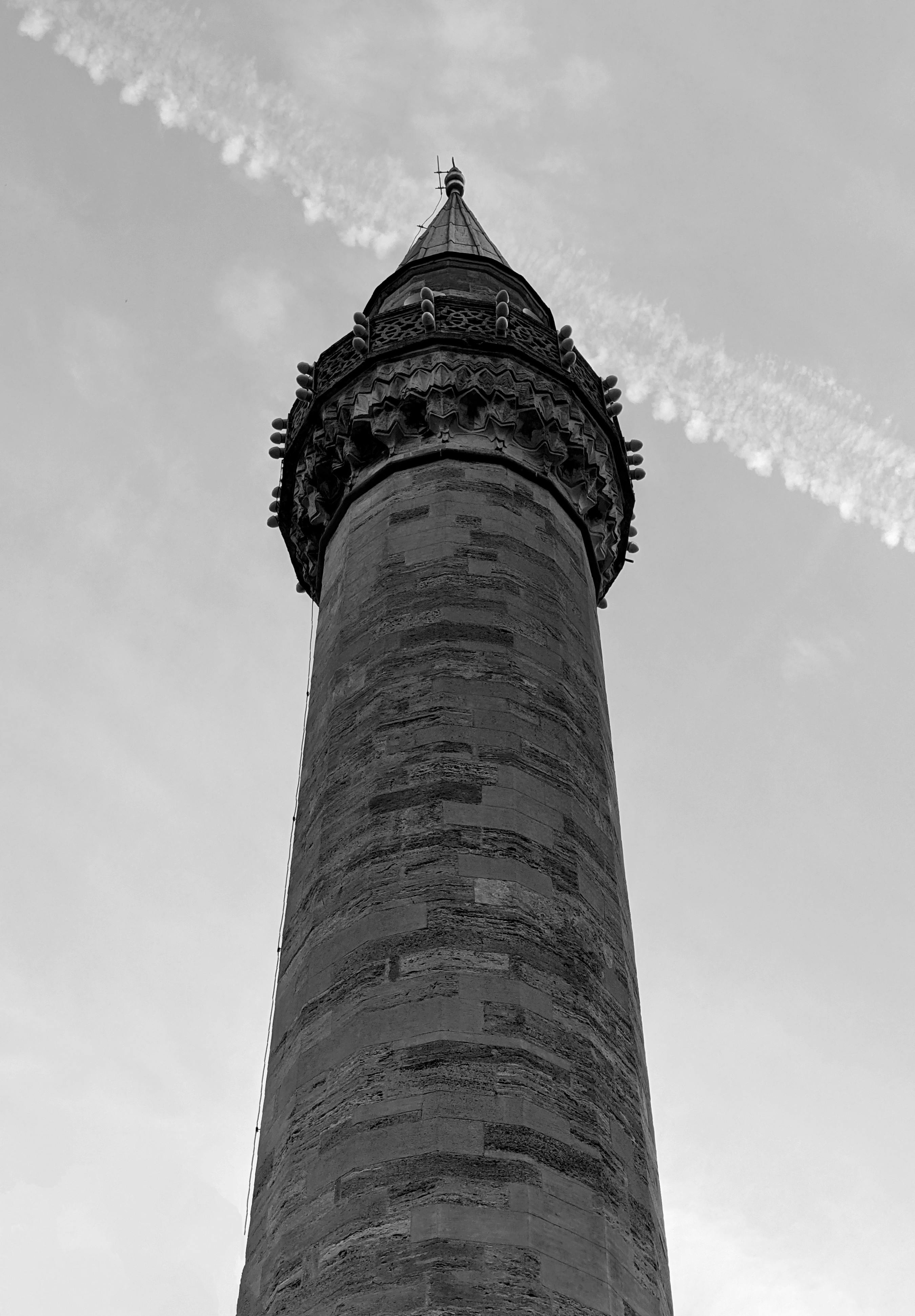 Old stone tower with spiky spire under blue cloudy sky · Free Stock Photo