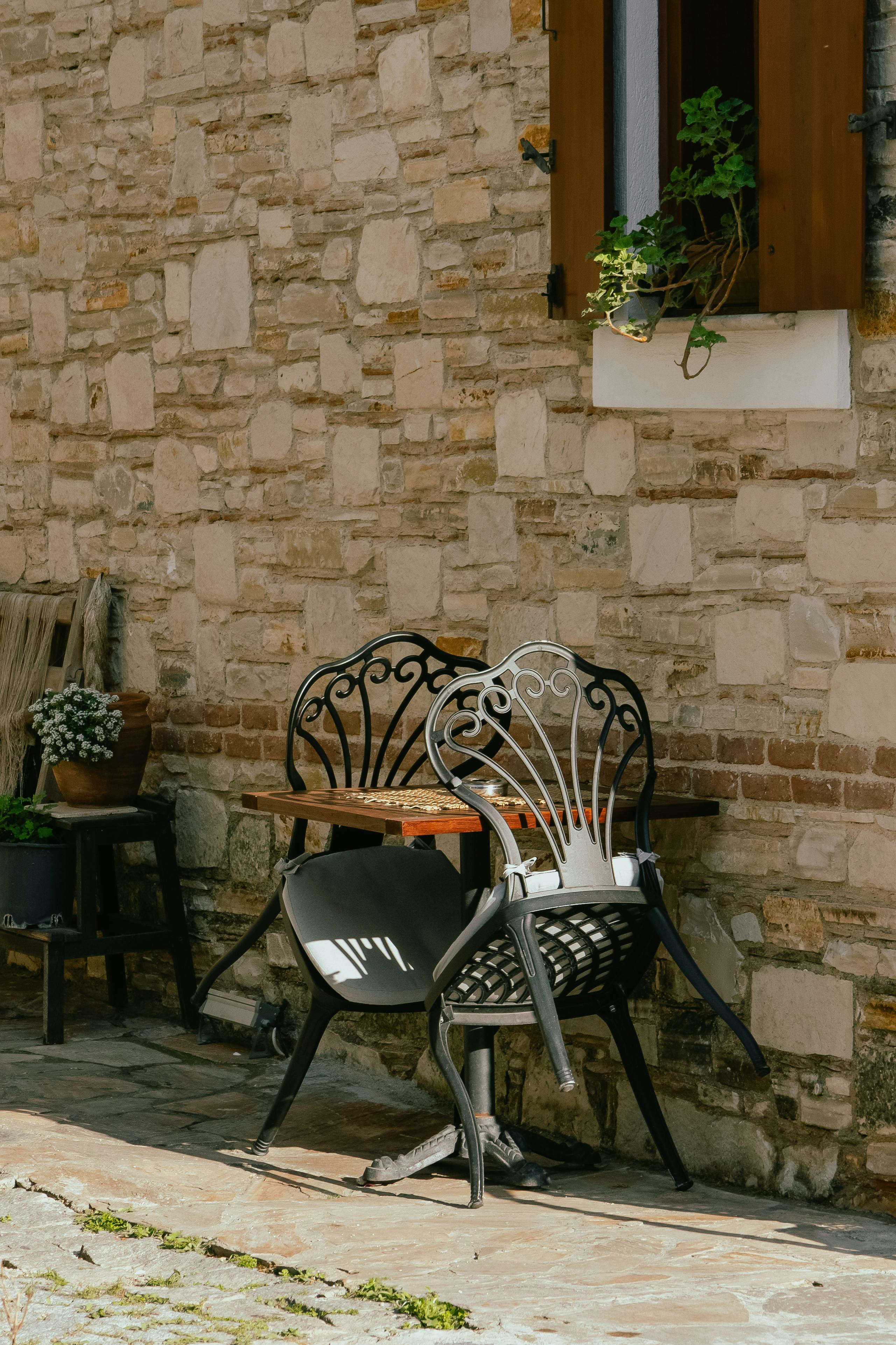 Outdoor Café Seating Against Stone Wall · Free Stock Photo