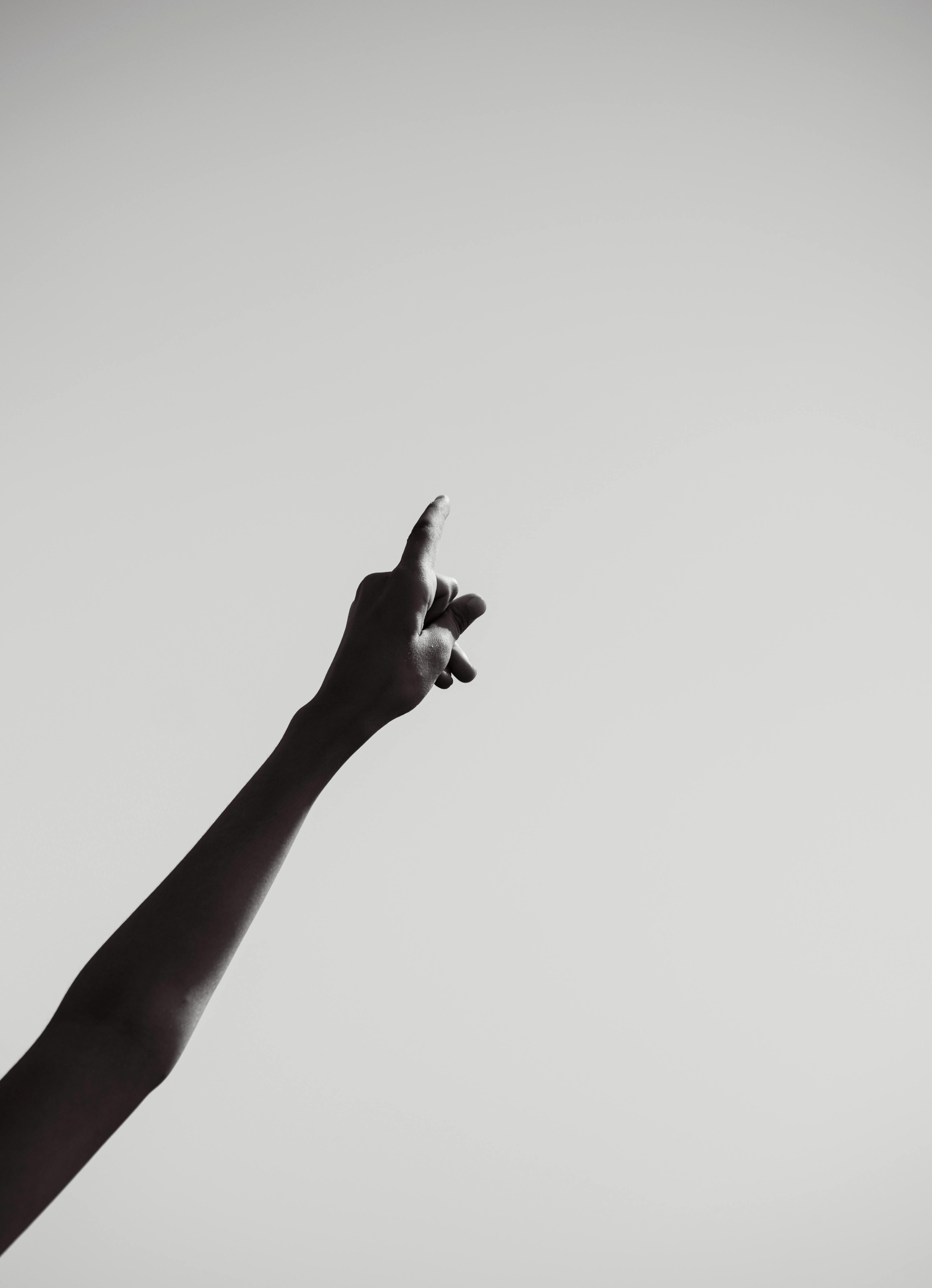 A person pointing up with their hand · Free Stock Photo