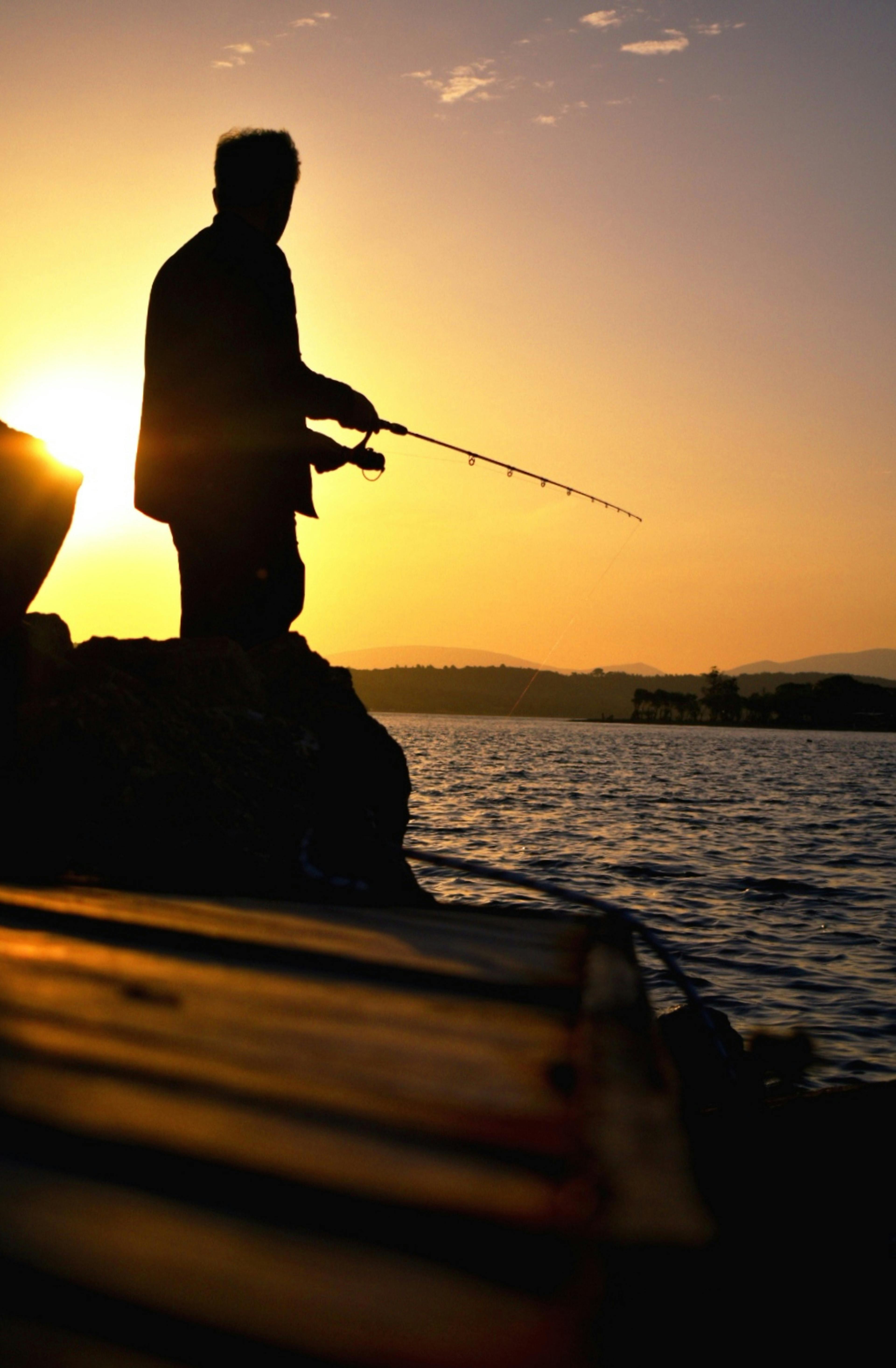 Angler Fishing in the Sea at Sunset · Free Stock Photo