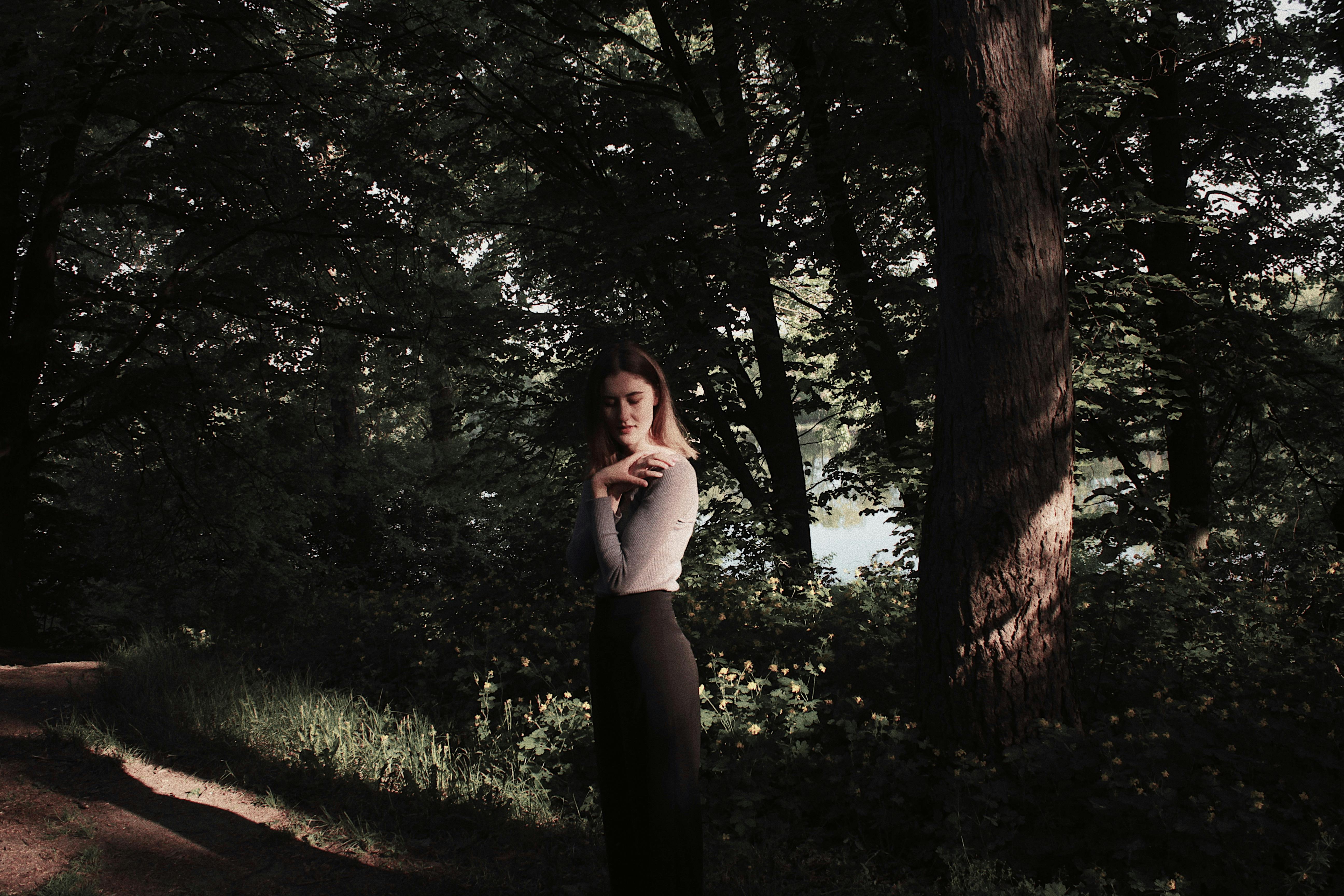Woman Standing Beside Trees · Free Stock Photo