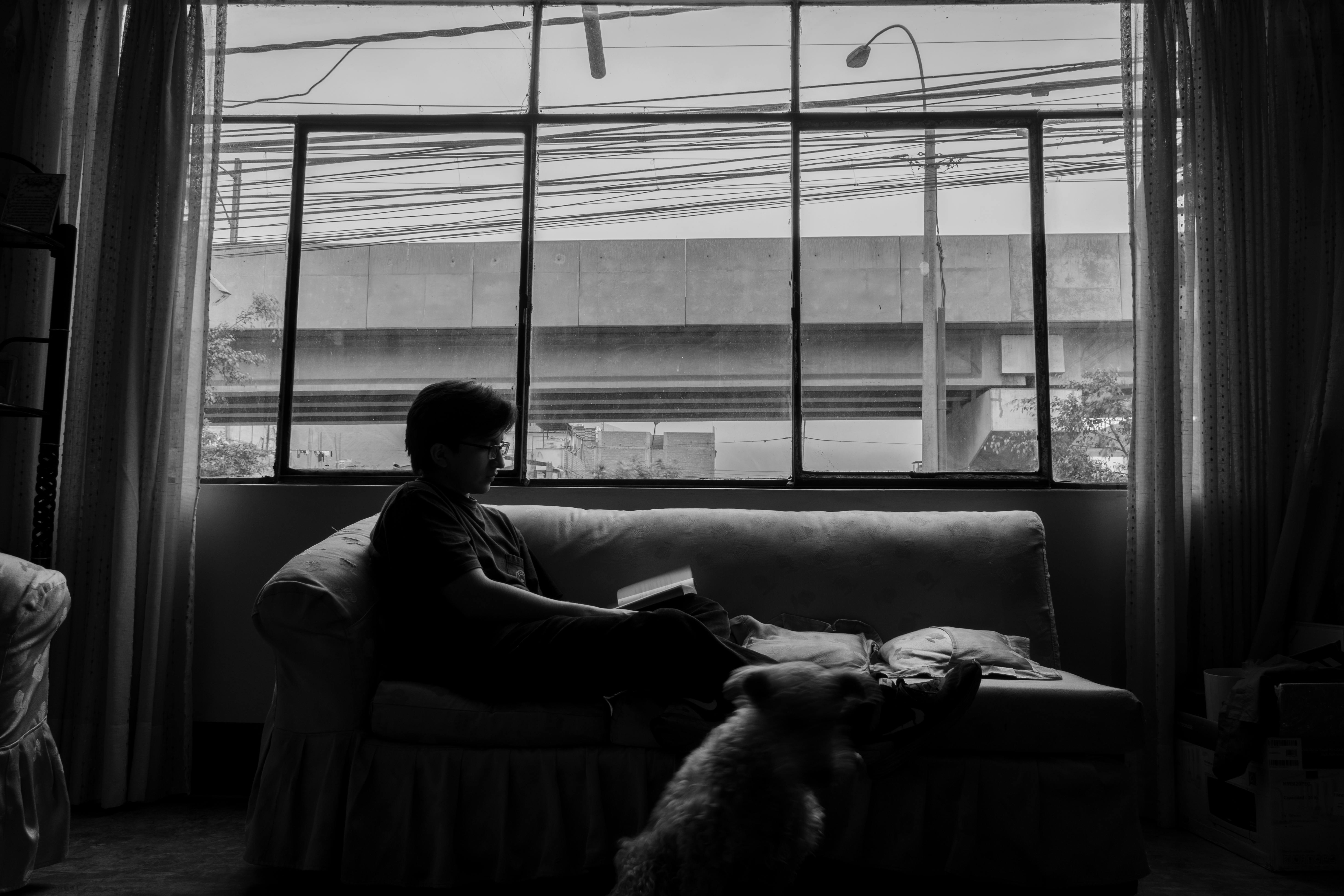 Person Sitting on Sofa and Reading Book · Free Stock Photo