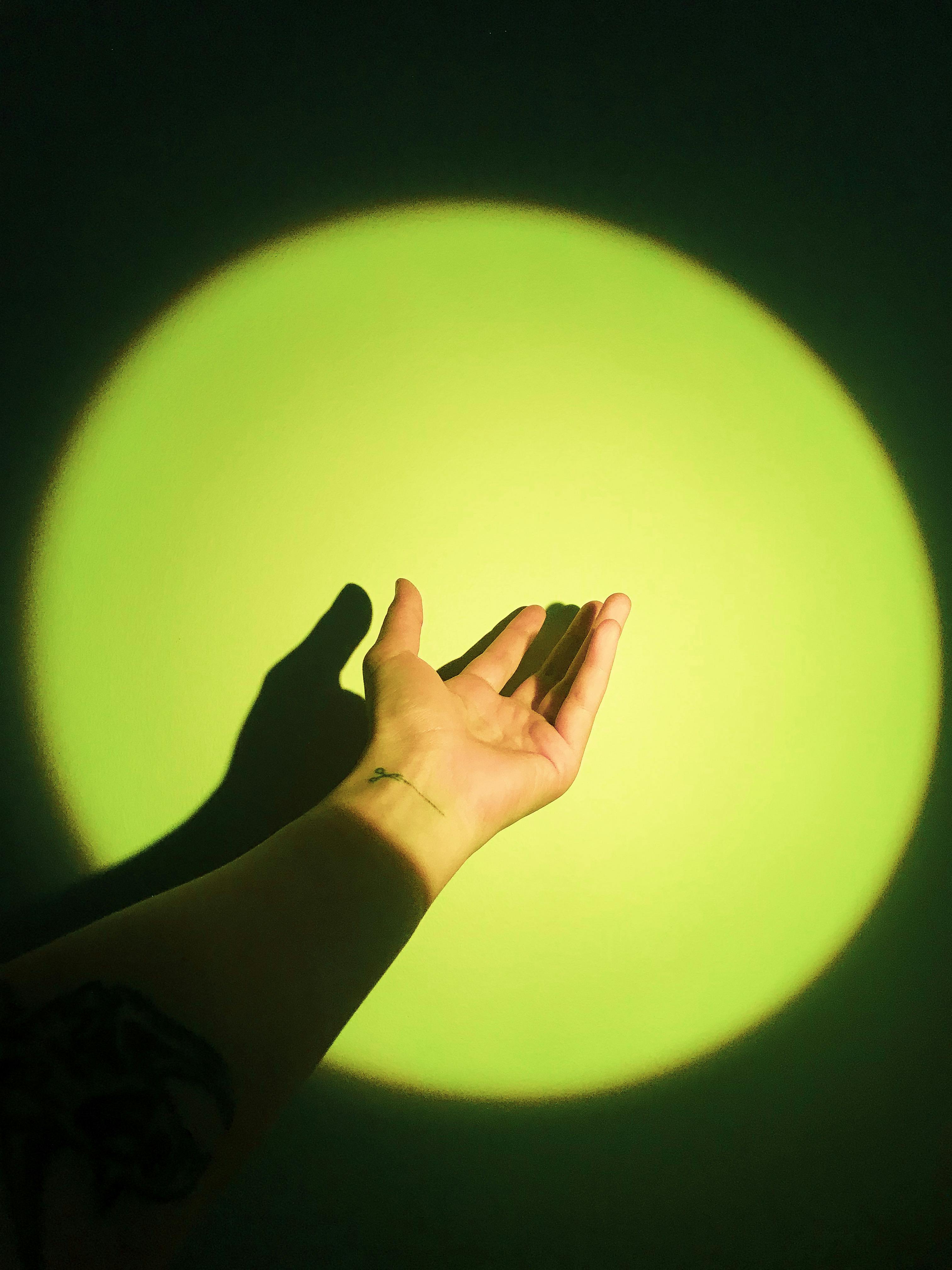 Tattoo on Hand of Person in Green Light Circle · Free Stock Photo