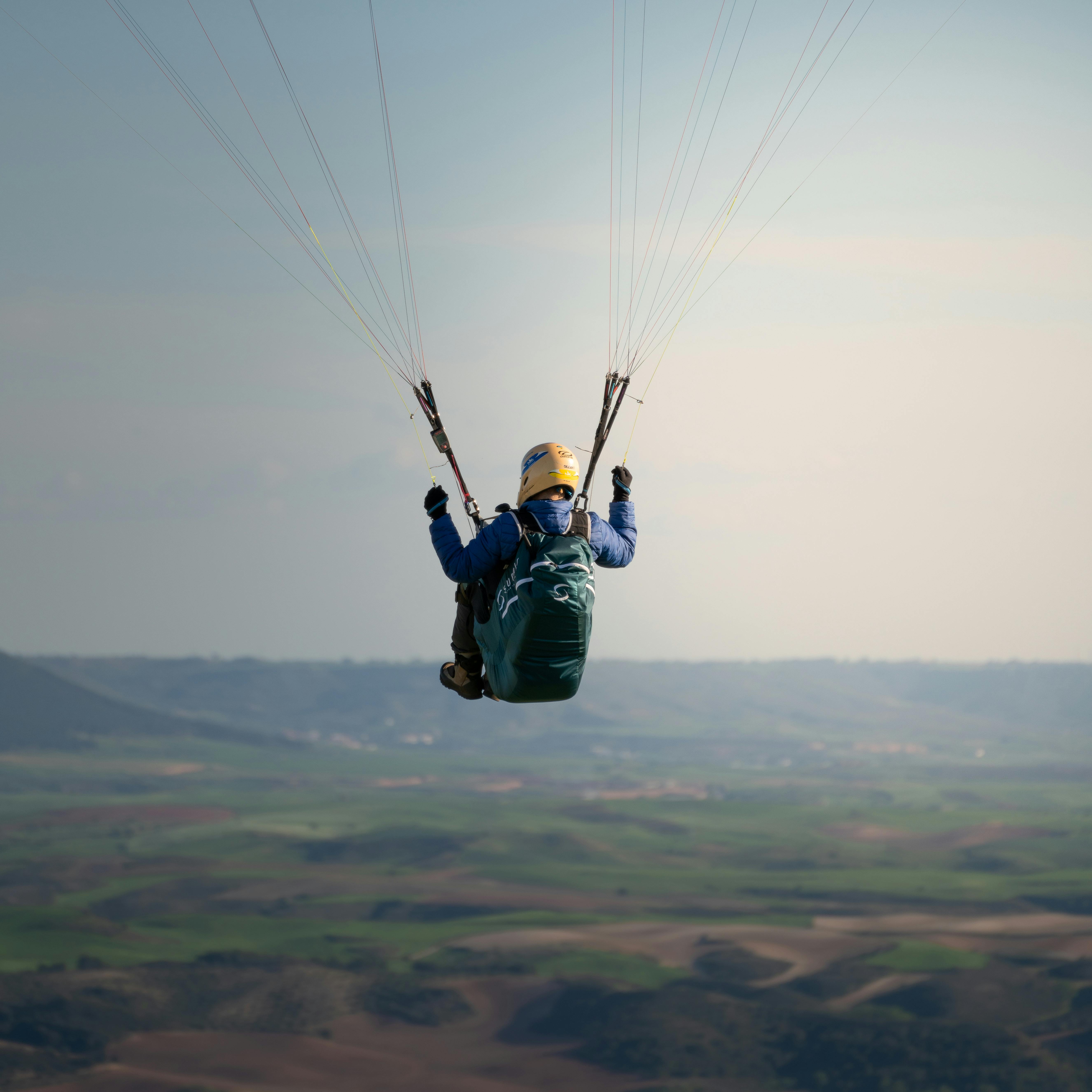 Back View of Person Parachuting in Countryside · Free Stock Photo