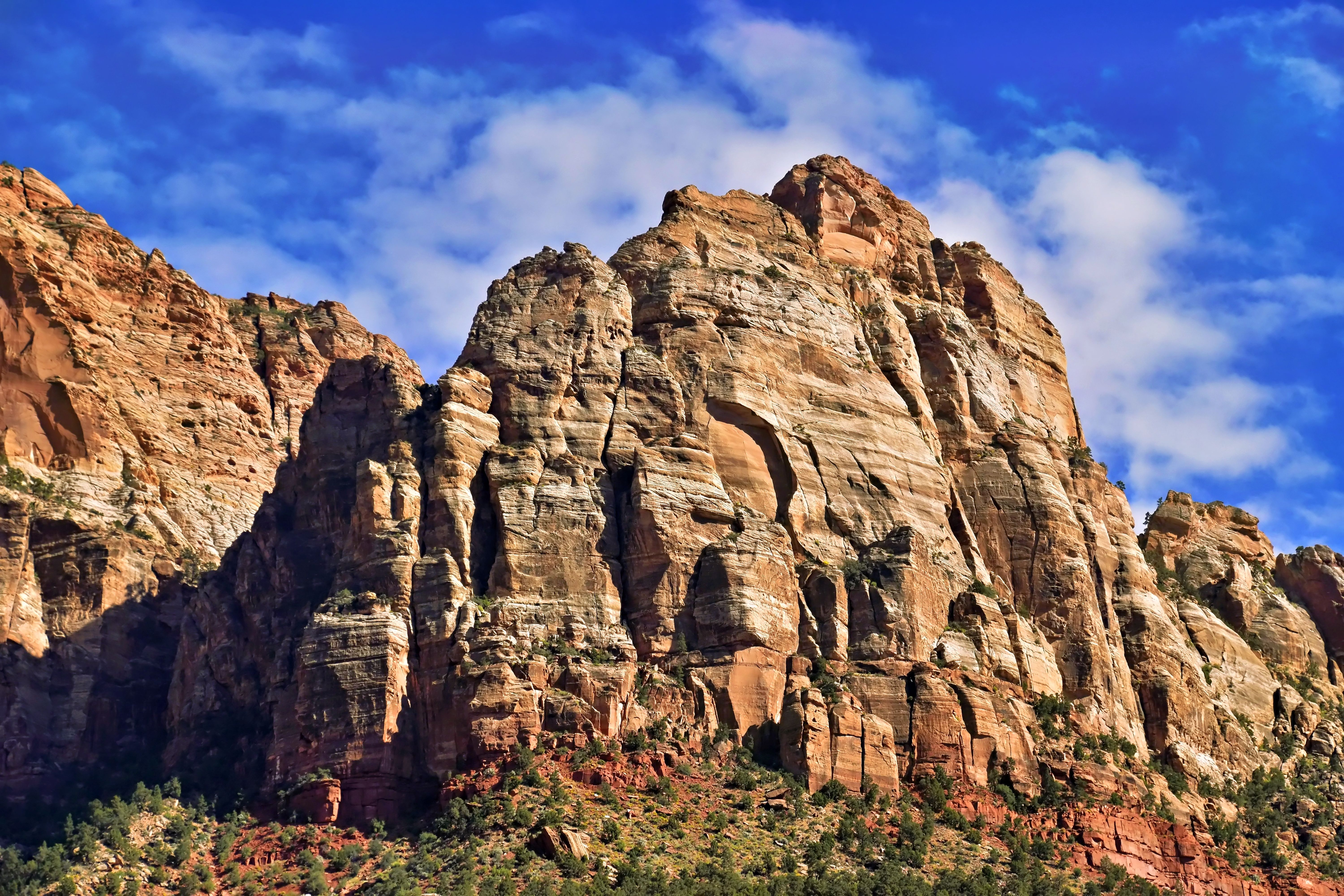 A large rock formation with blue sky and clouds · Free Stock Photo