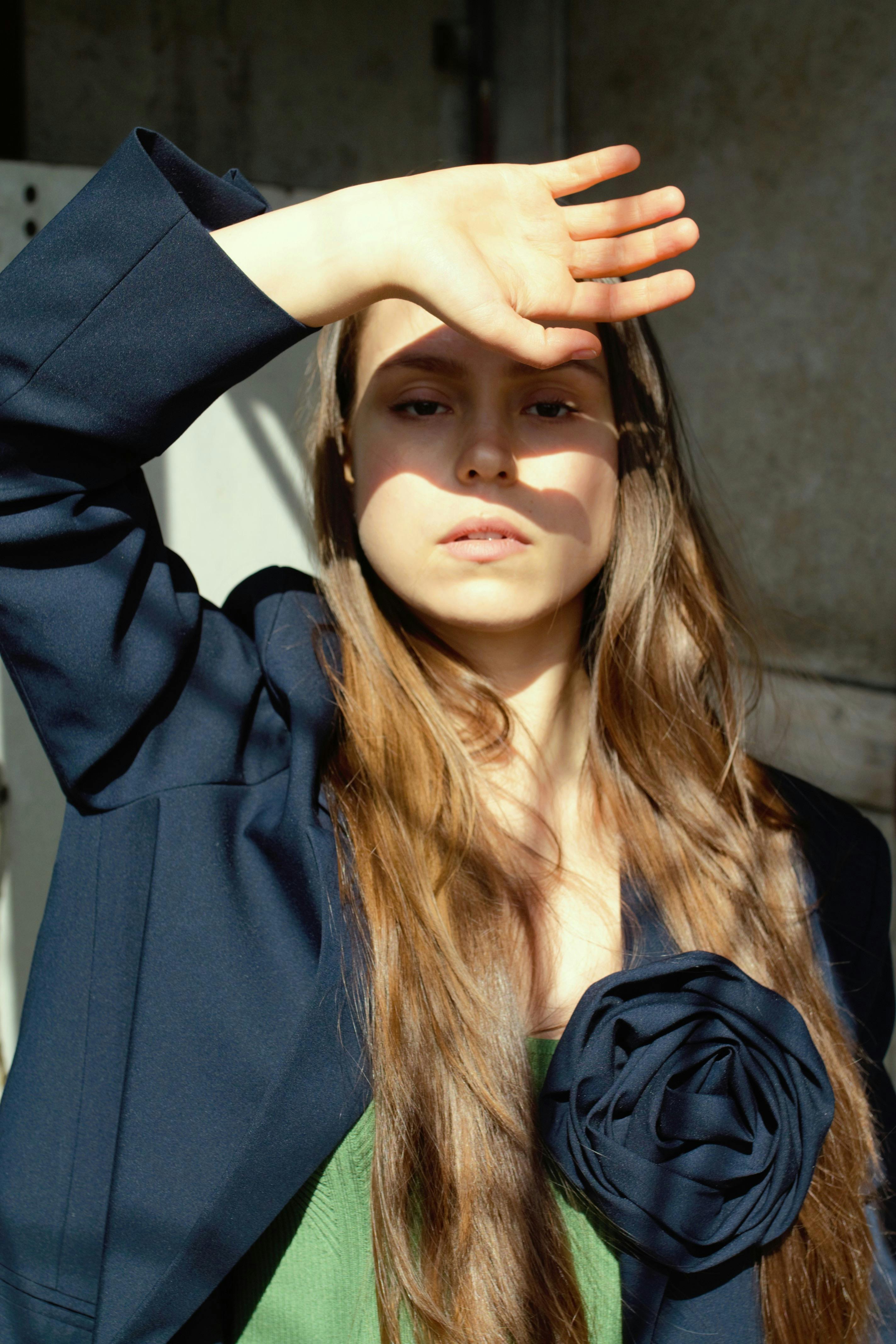 Portrait of Woman Shielding Face from Sun with Hand · Free Stock Photo
