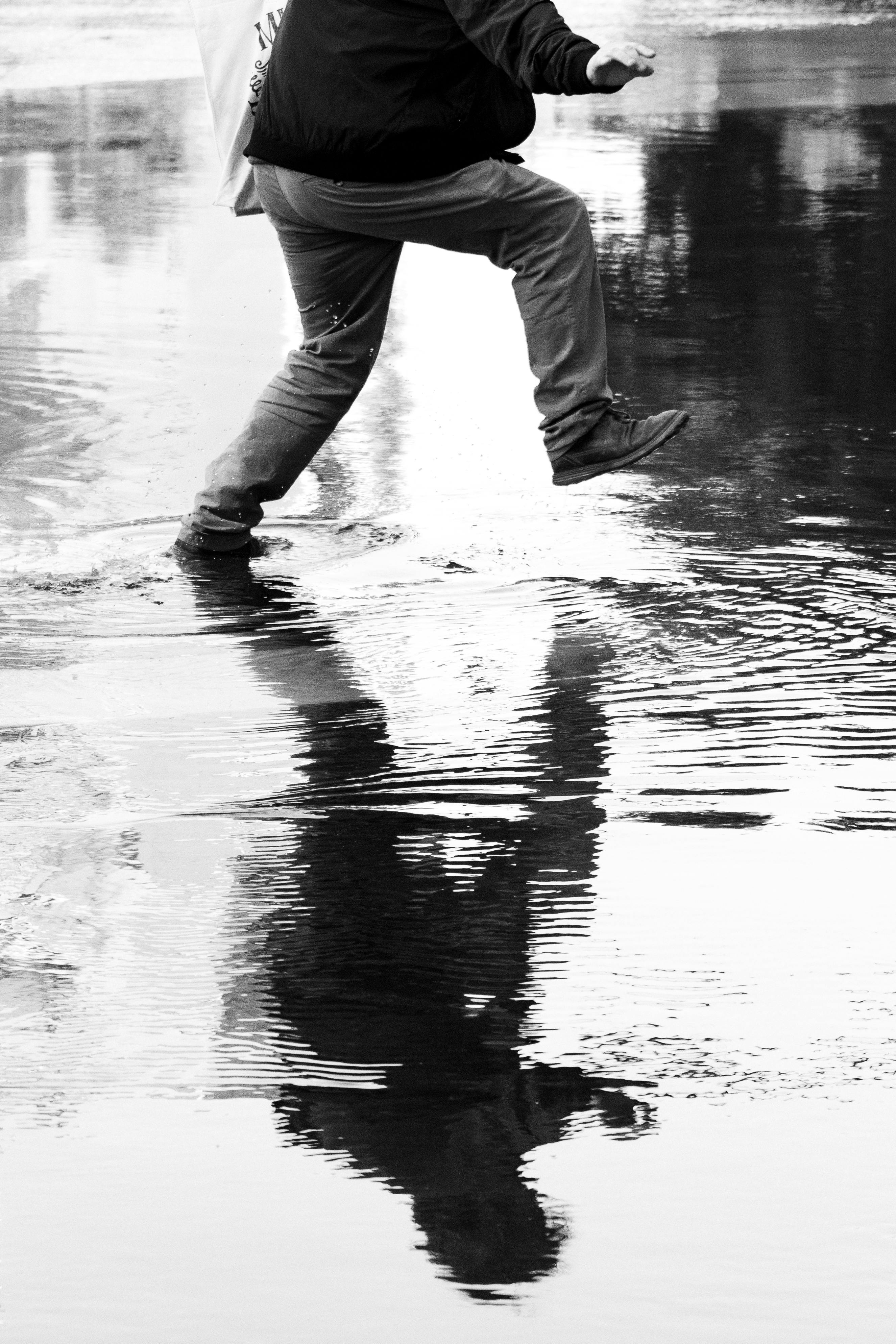 Woman running fast in splashing water on street · Free Stock Photo