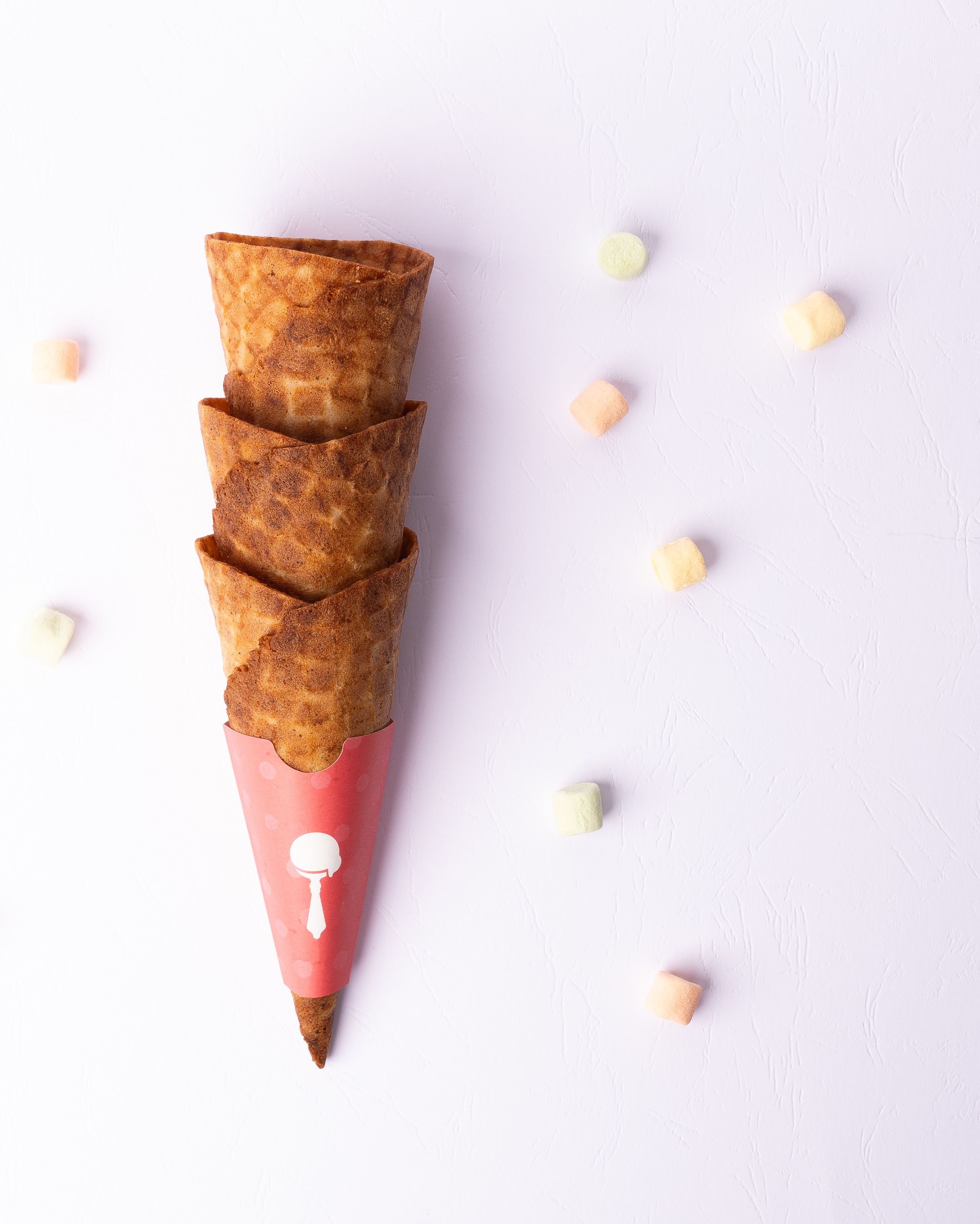 Three ice cream cones and small pastel colored candies · Free Stock Photo