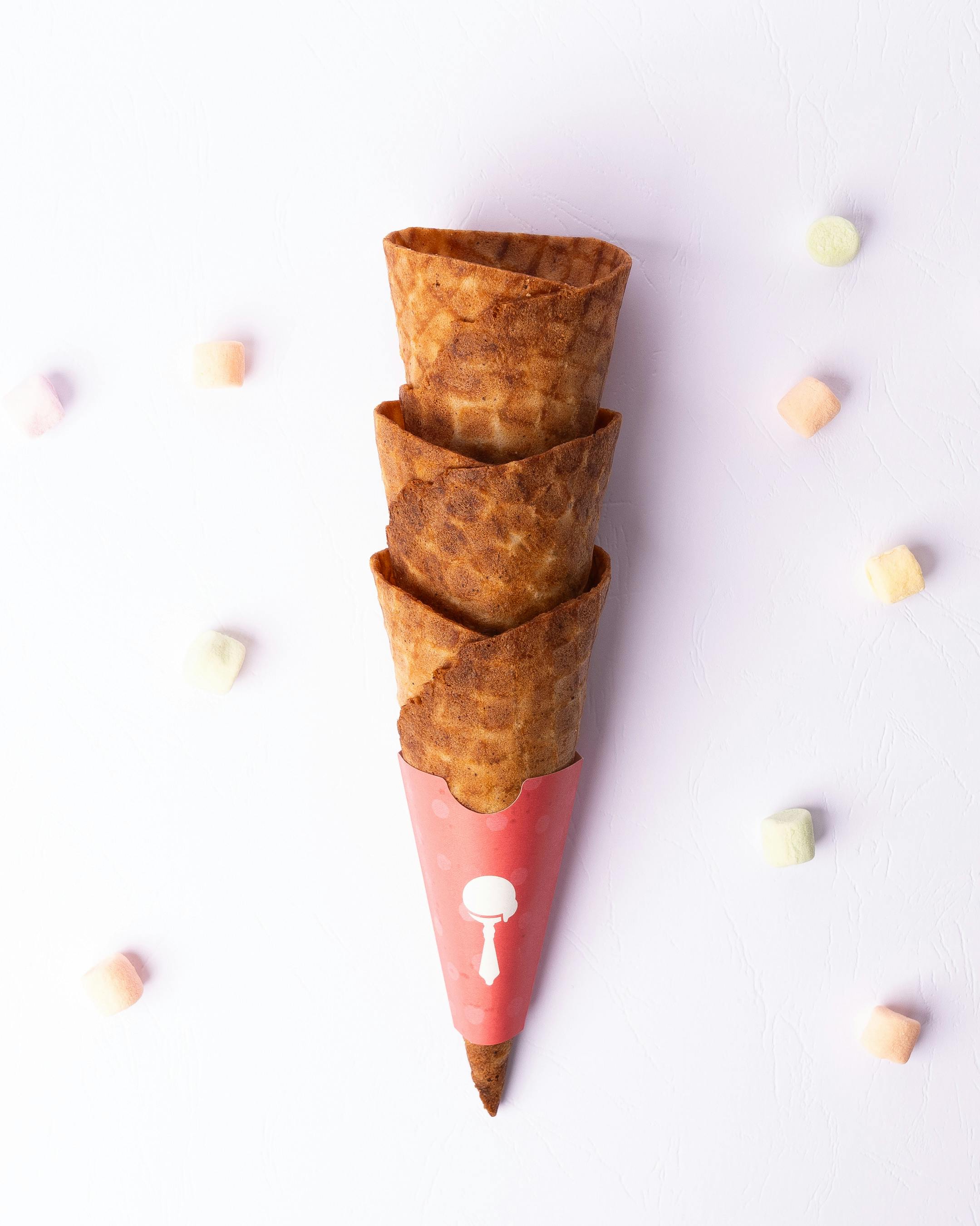 Three ice cream cones and small pastel colored candies · Free Stock Photo