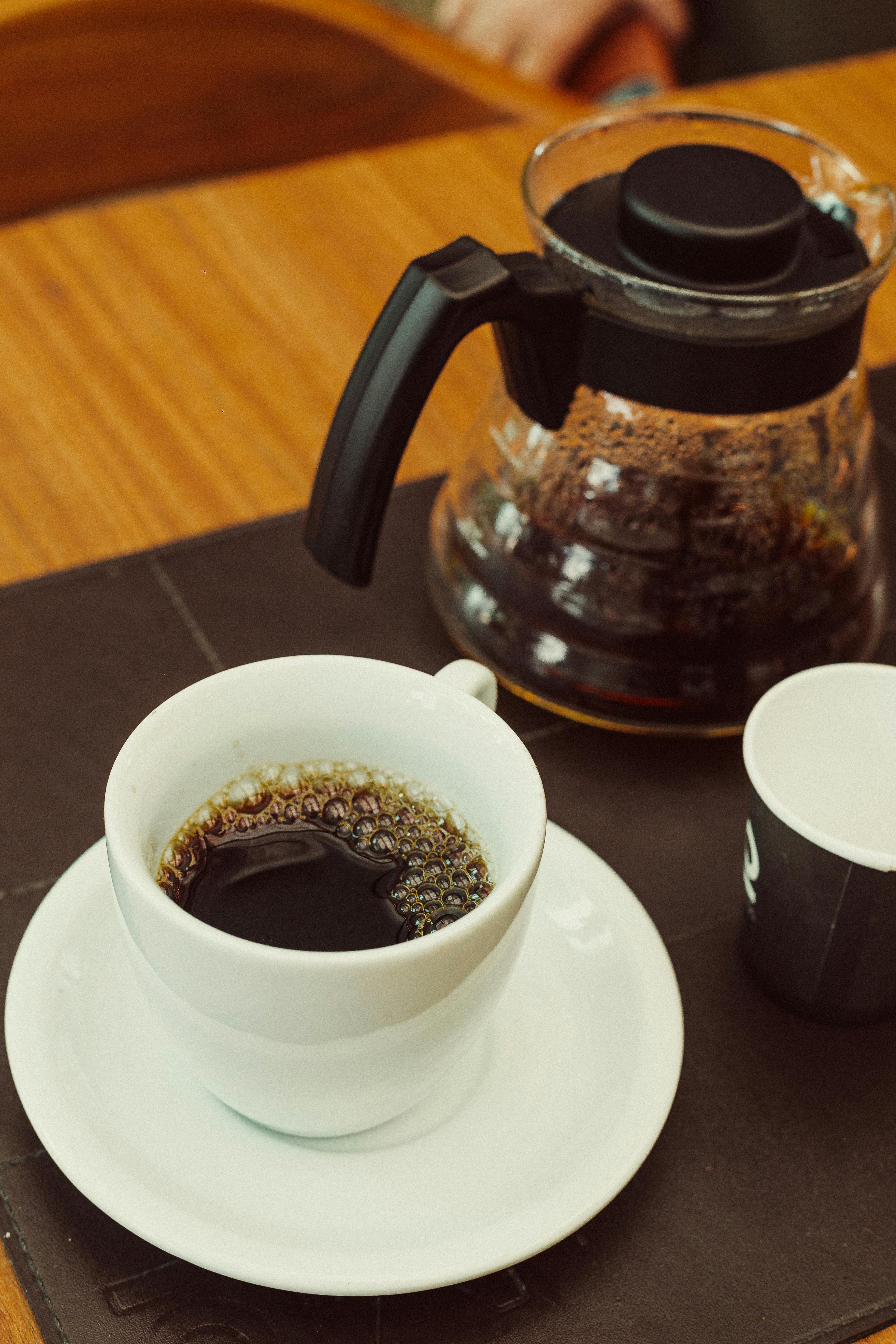 Cup of Coffee by Disposable Cup and Jug of Coffee · Free Stock Photo