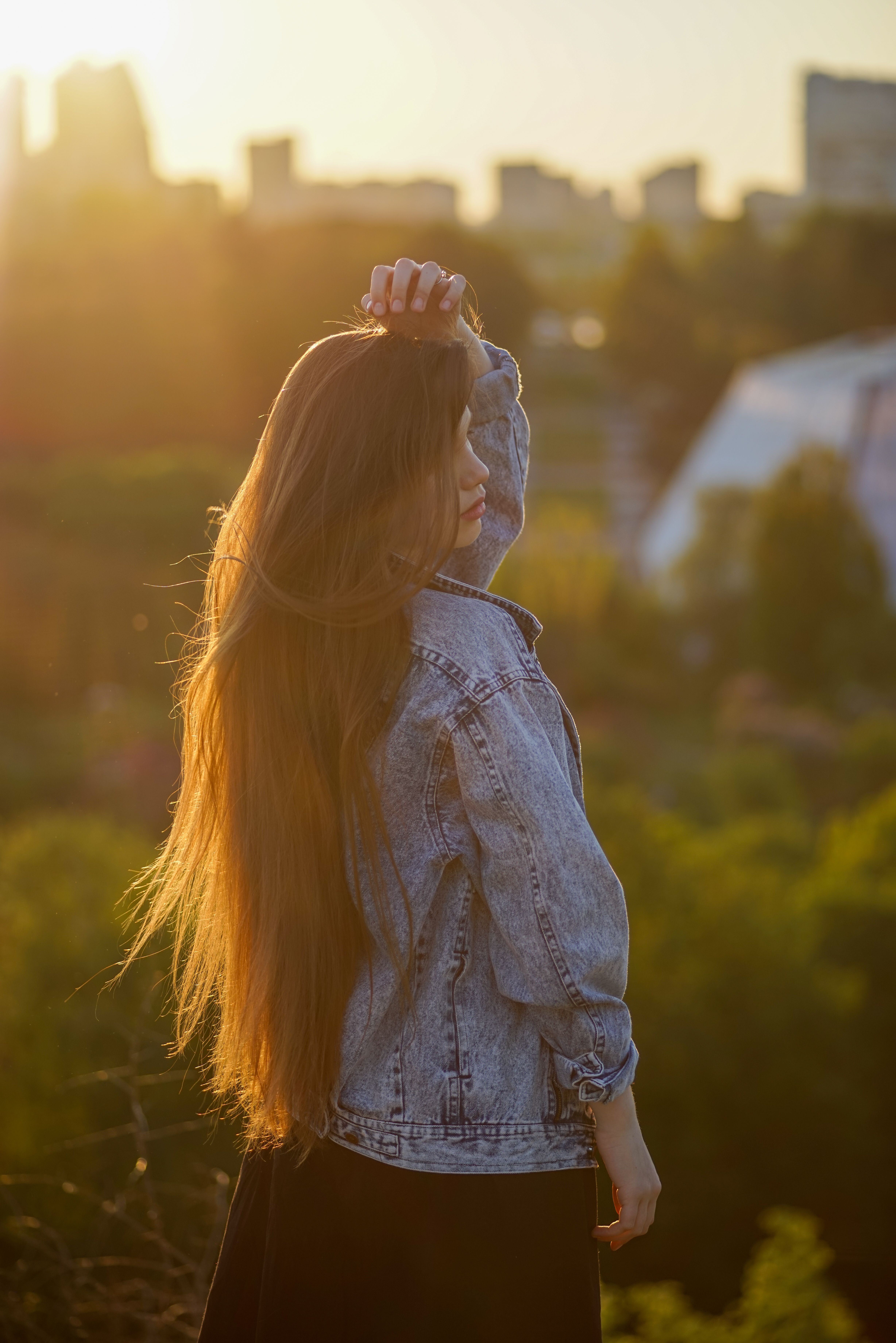 A Woman with Long Hair Standing Outside at Sunset · Free Stock Photo
