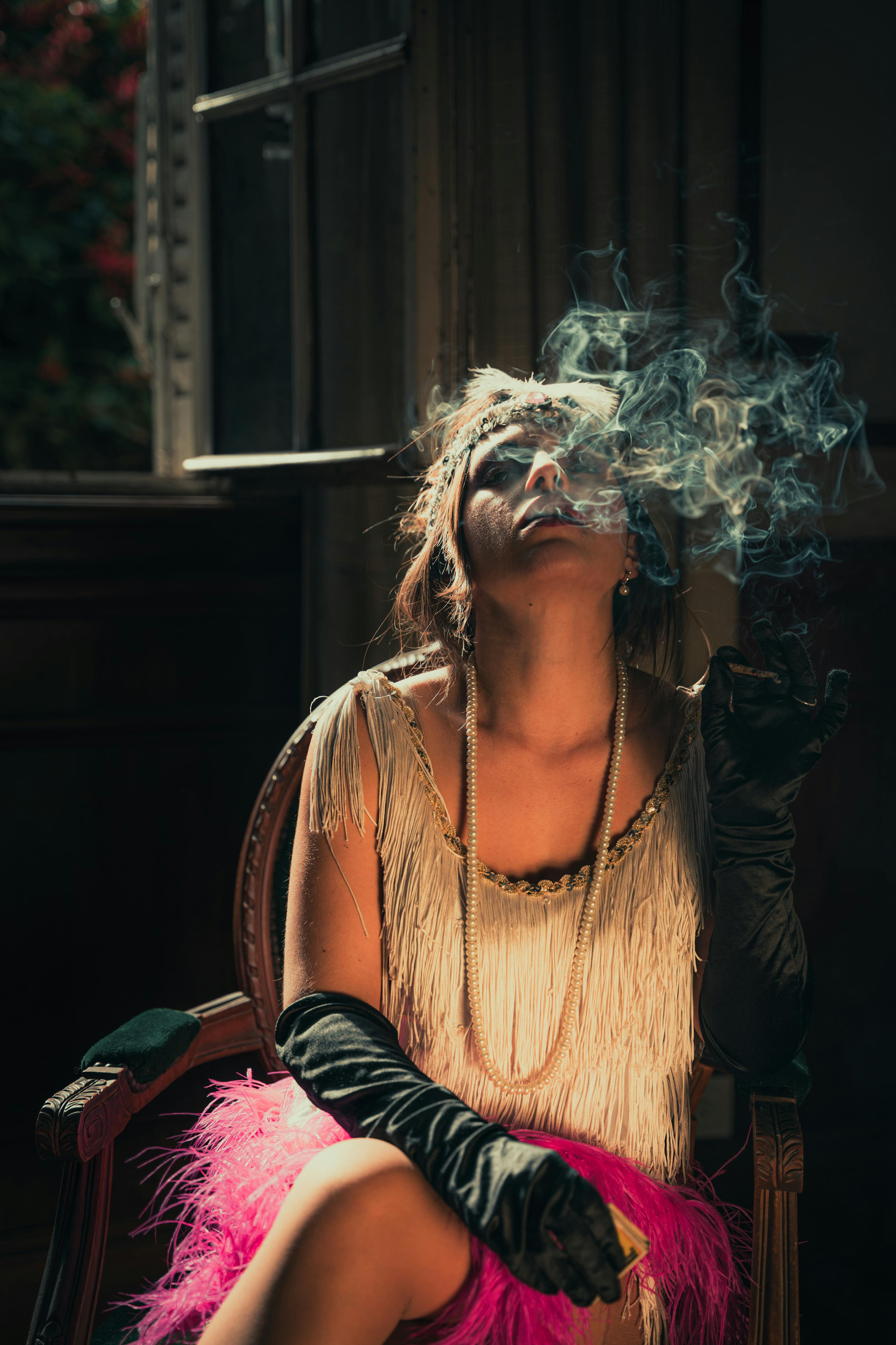Woman in a 1920s Style Flapper Dress and Long Gloves Smoking a Cigarette · Free Stock Photo