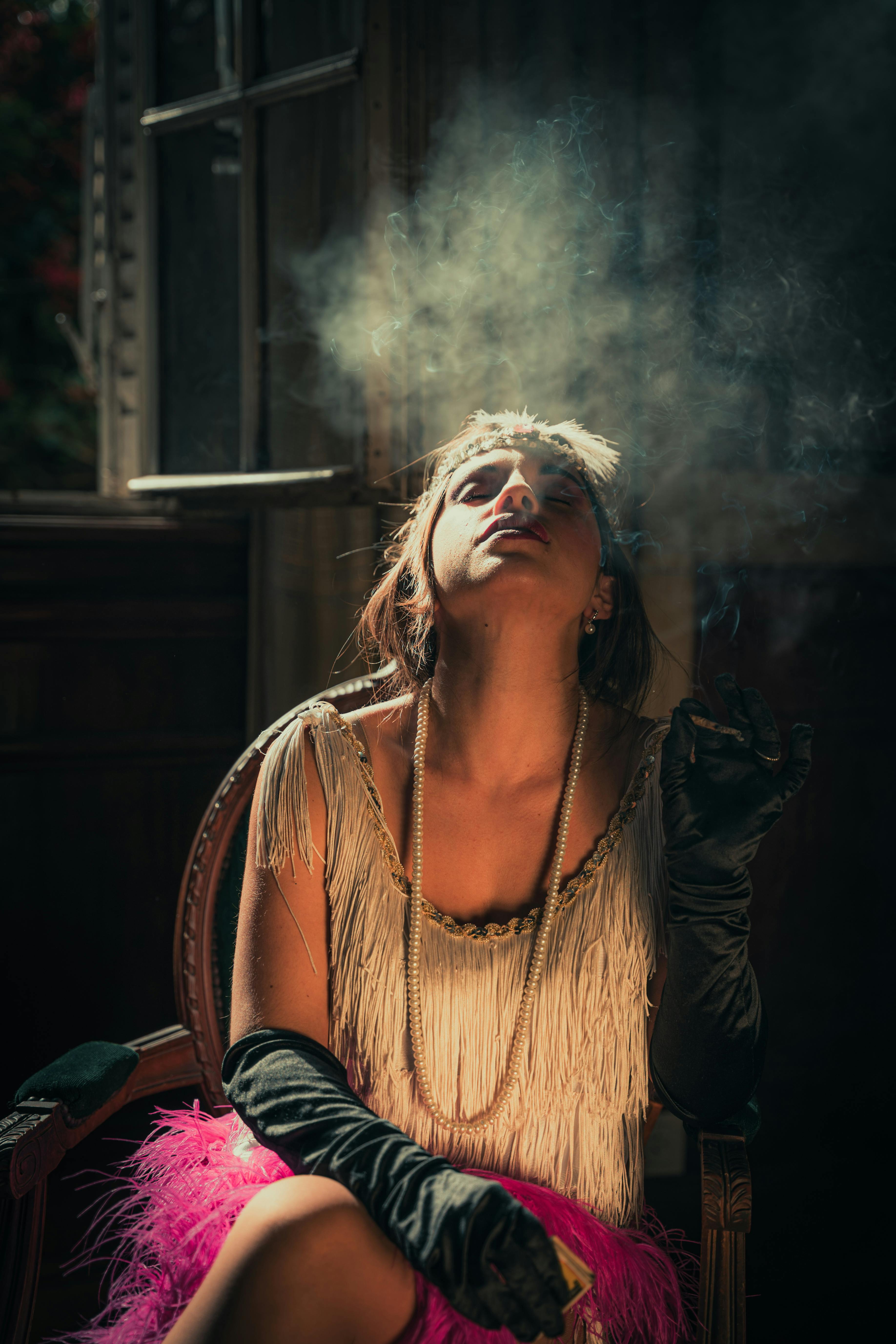 Beautiful Woman Sitting and Exhaling Smoke · Free Stock Photo