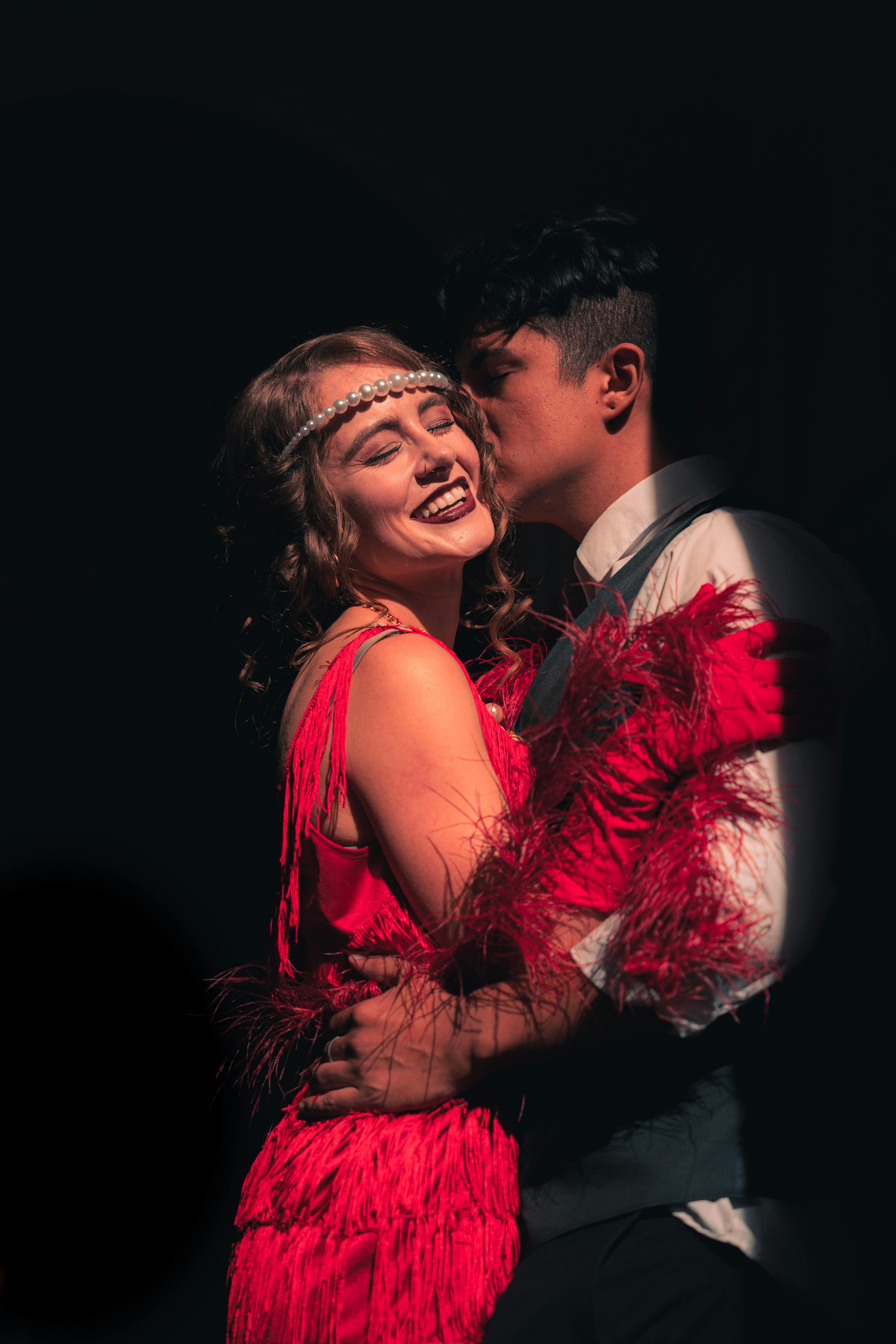 Man Kissing a Woman Wearing Red Flapper Dress · Free Stock Photo