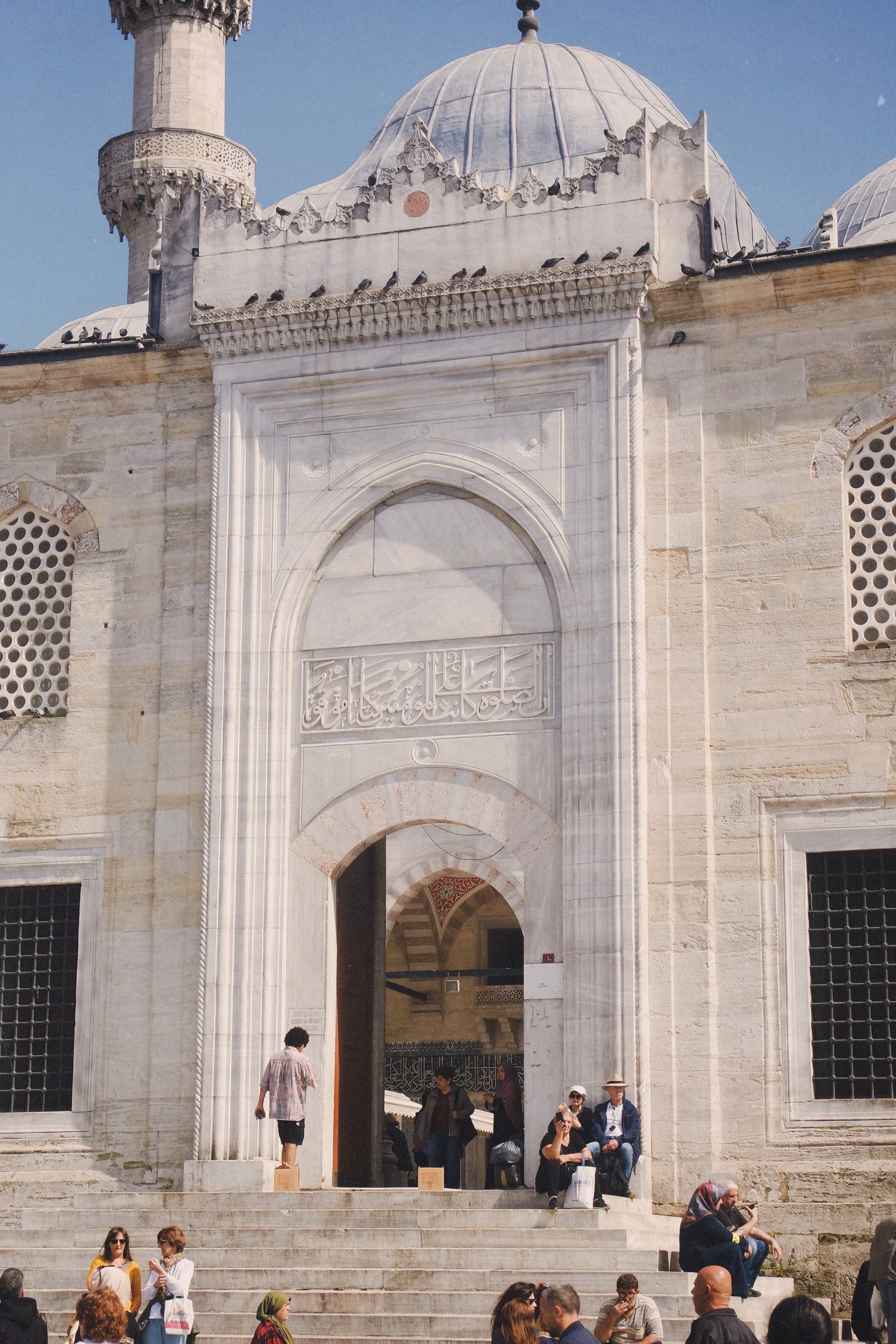 People are walking around the outside of a mosque · Free Stock Photo