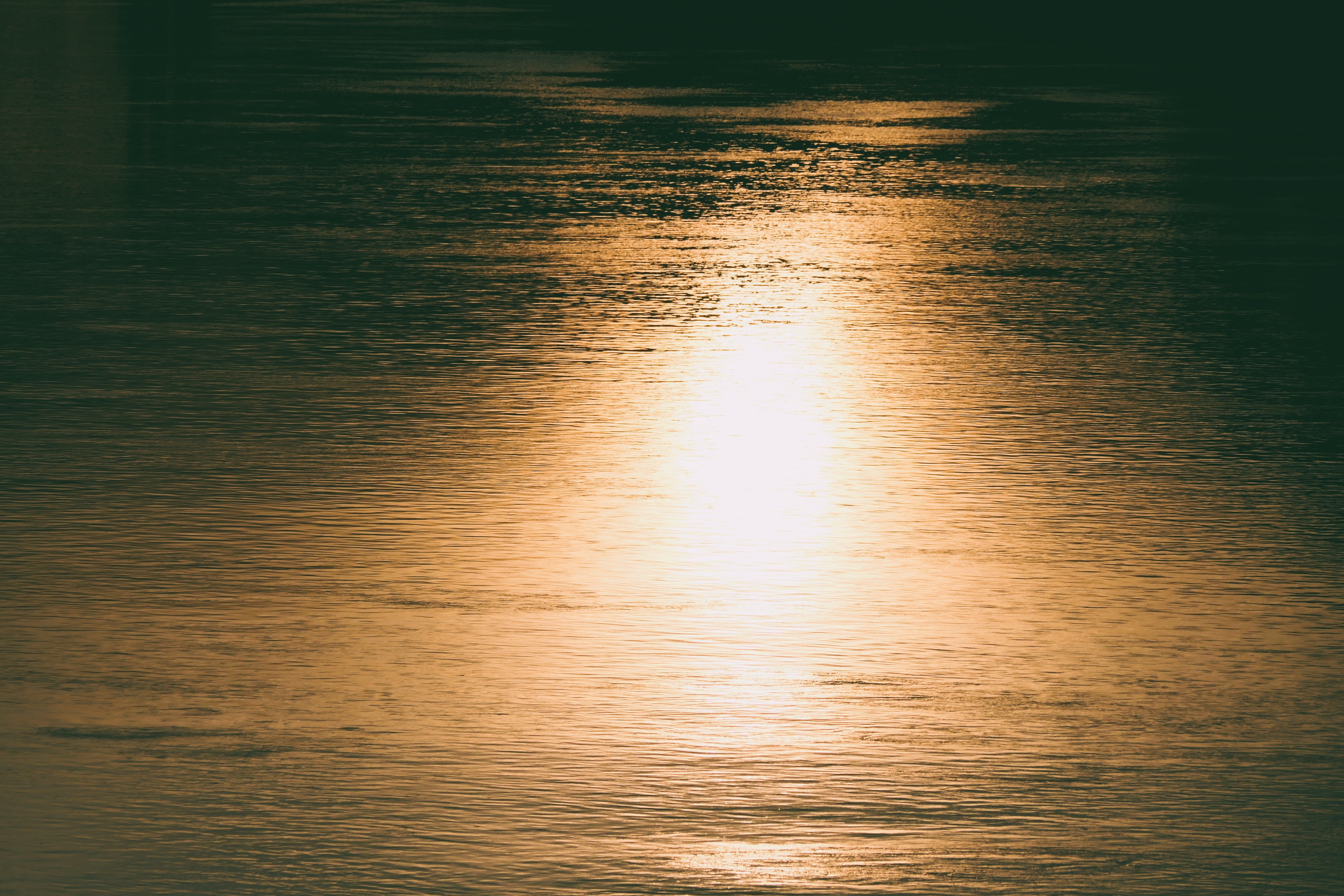 View of a Water Surface Reflecting Bright Sunset Light · Free Stock Photo