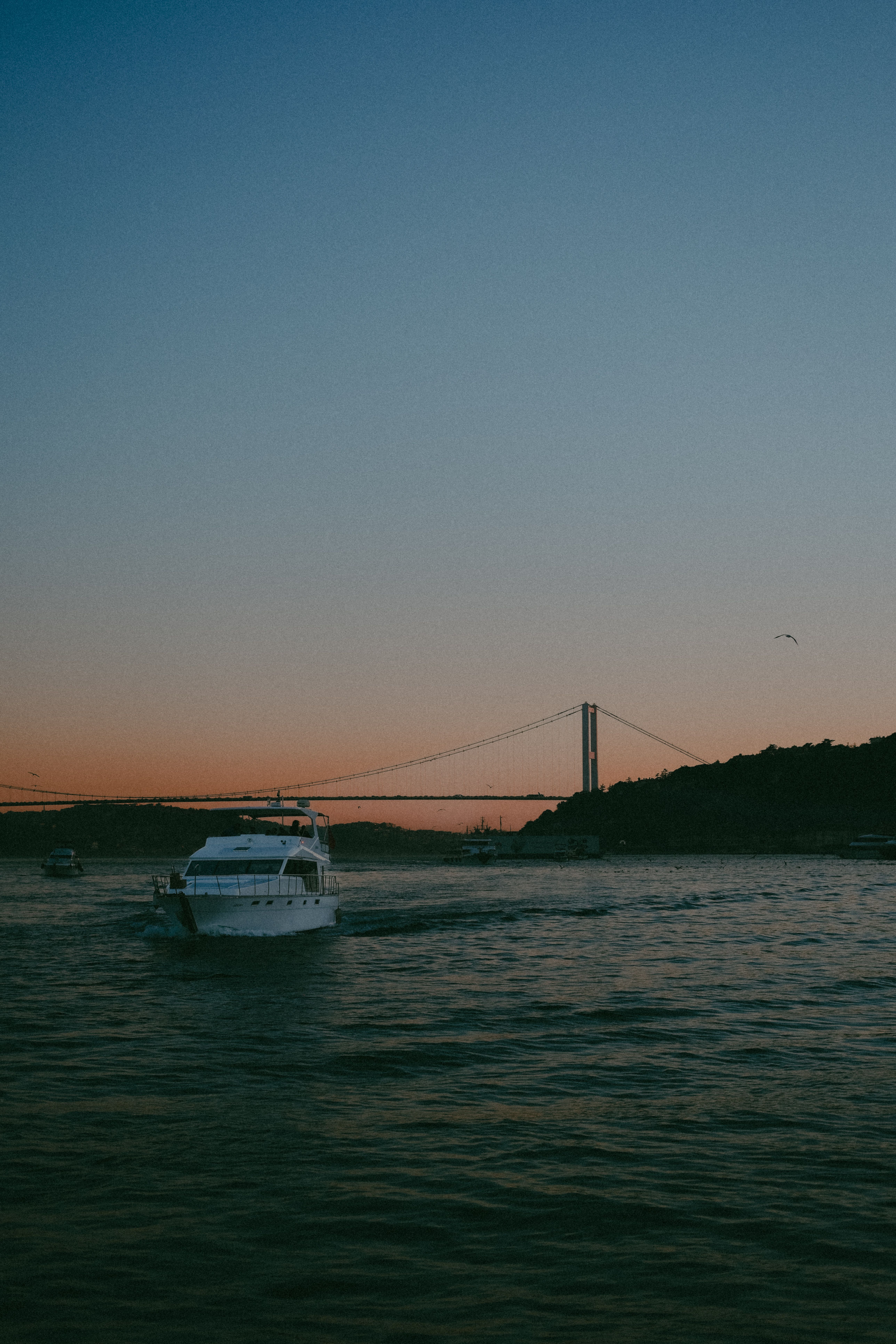 A boat is traveling across the water at sunset · Free Stock Photo