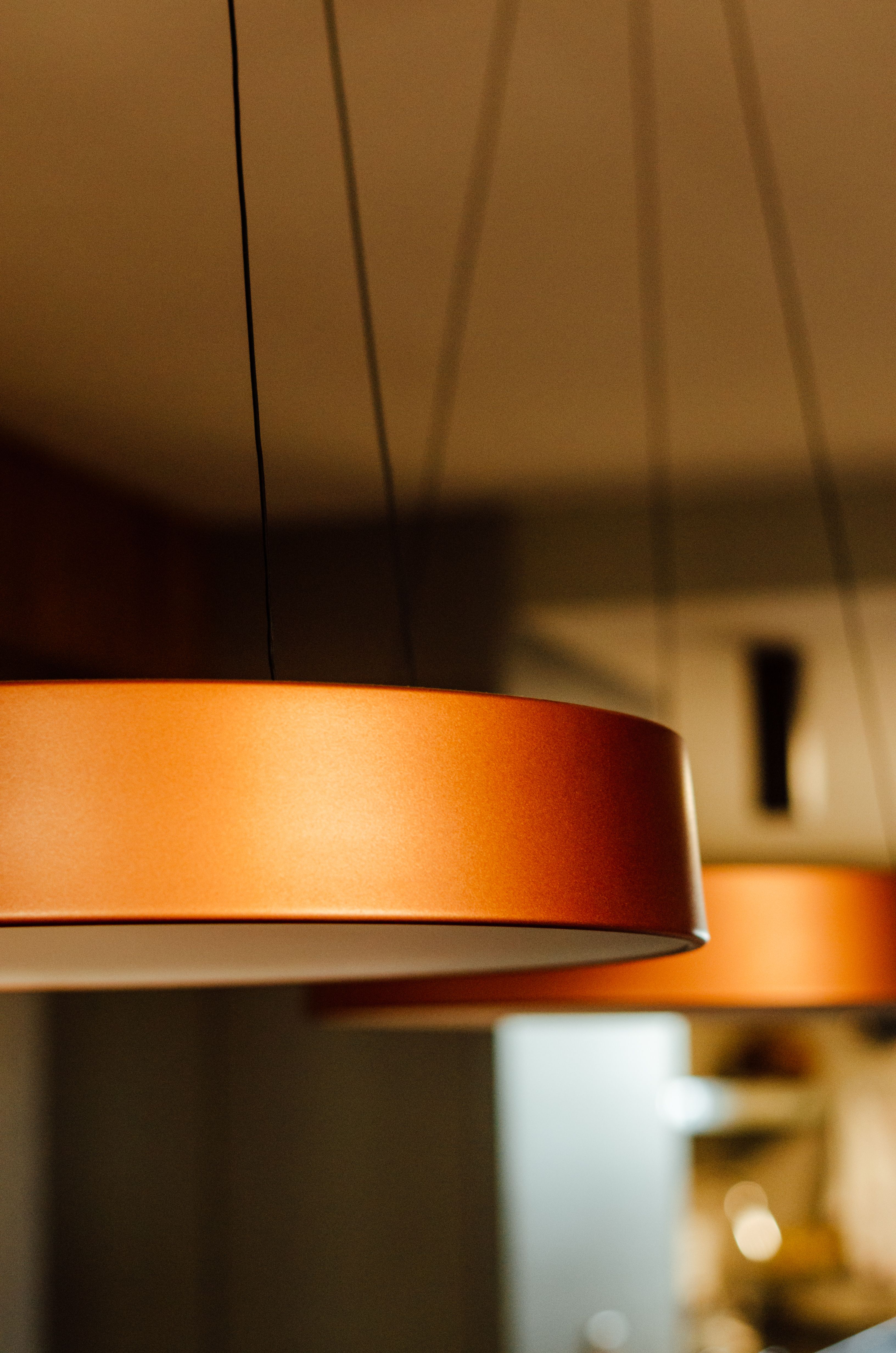 Close-up of Orange Lamps Hanging Low from the Ceiling · Free Stock Photo