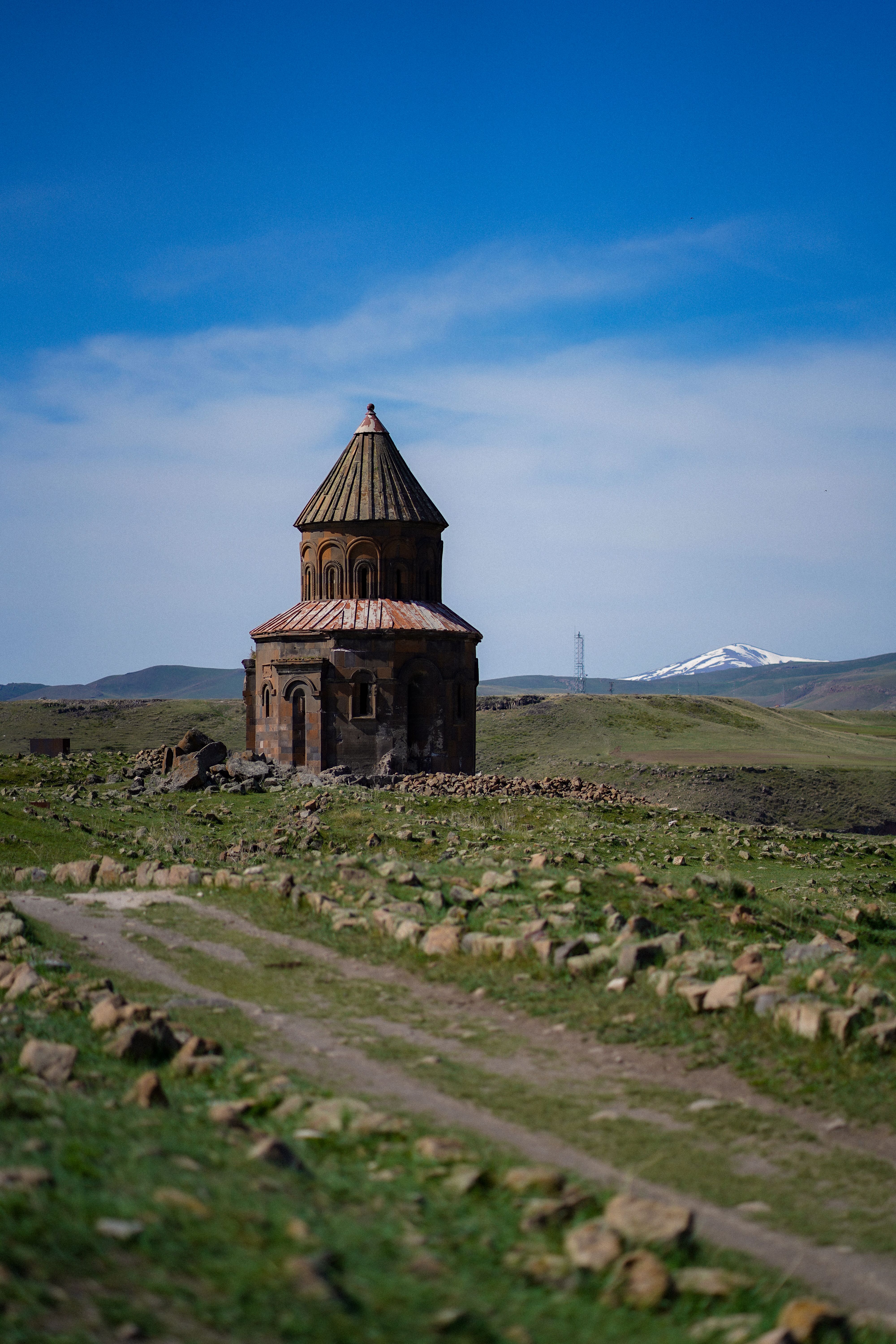 A small stone church sits on a hillside · Free Stock Photo
