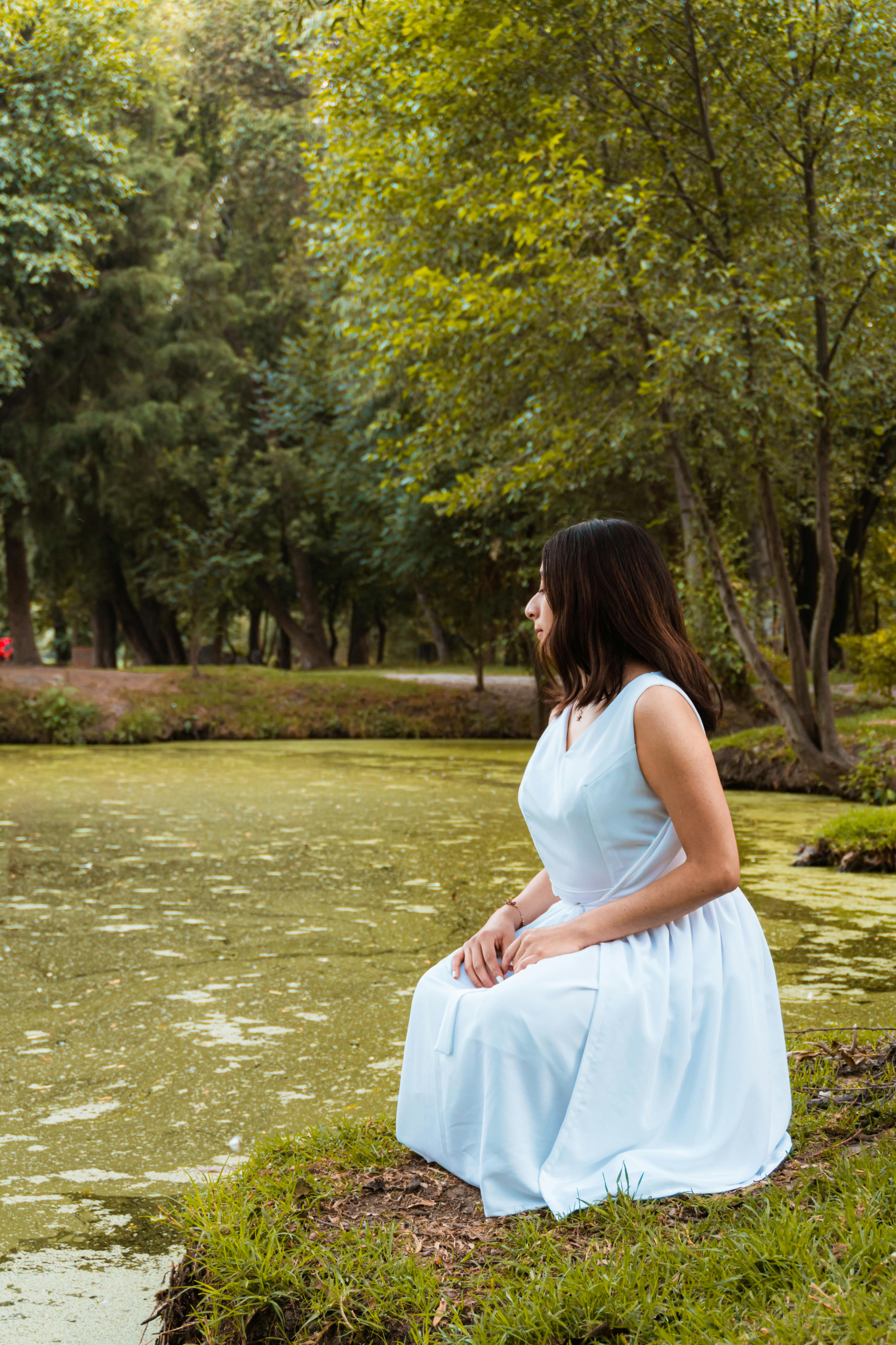 Woman Crouching by Pond in Park · Free Stock Photo