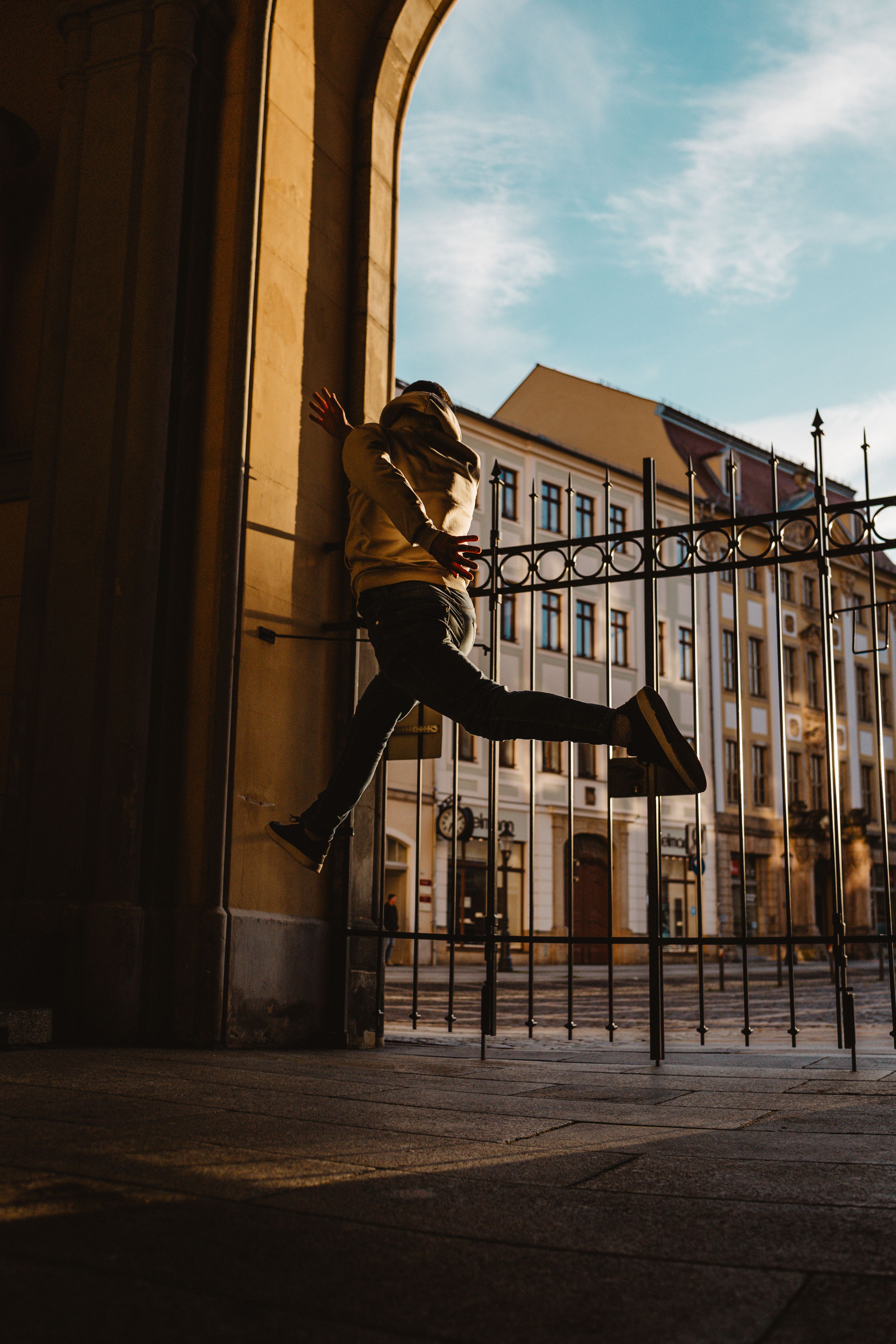 A person jumping in the air in front of a gate · Free Stock Photo