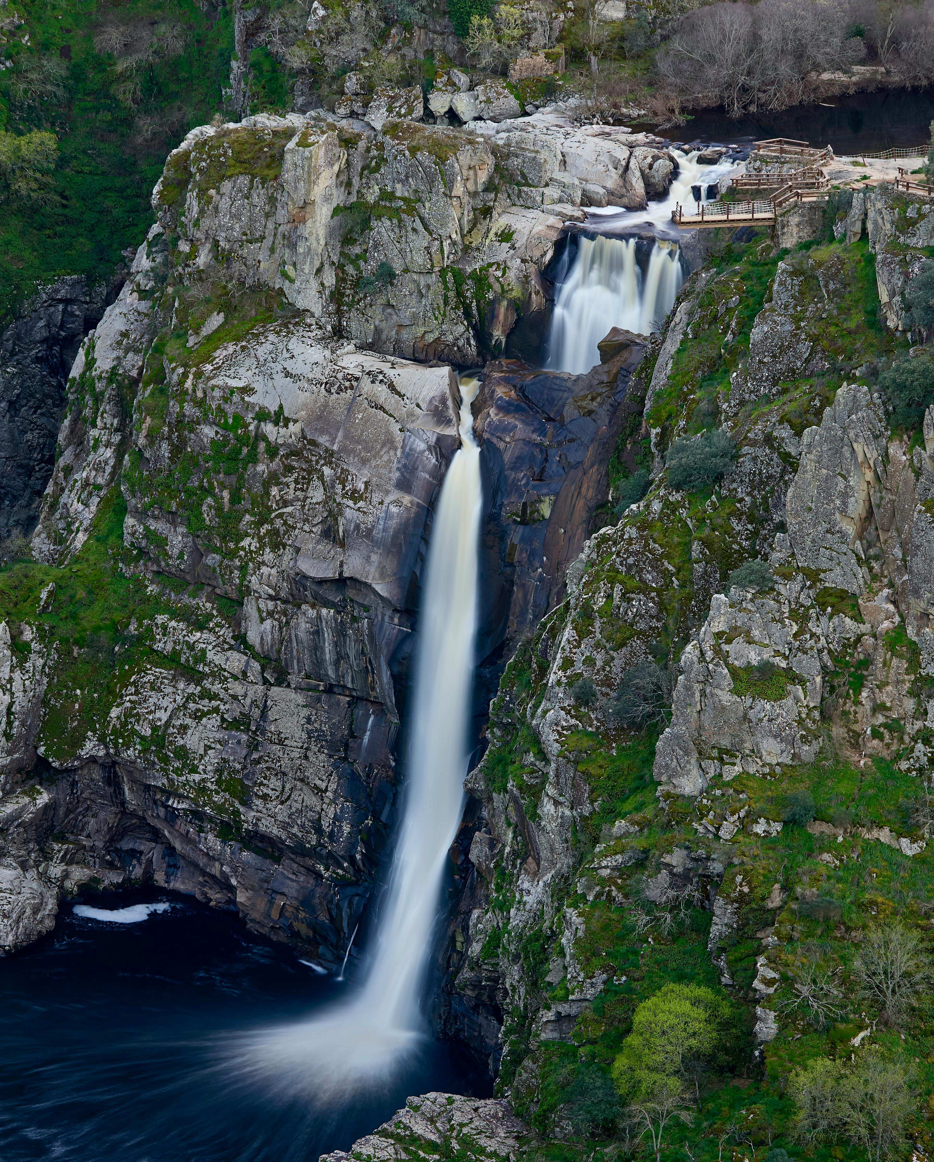 Aerial view of a waterfall in the middle of a rocky cliff · Free Stock ...