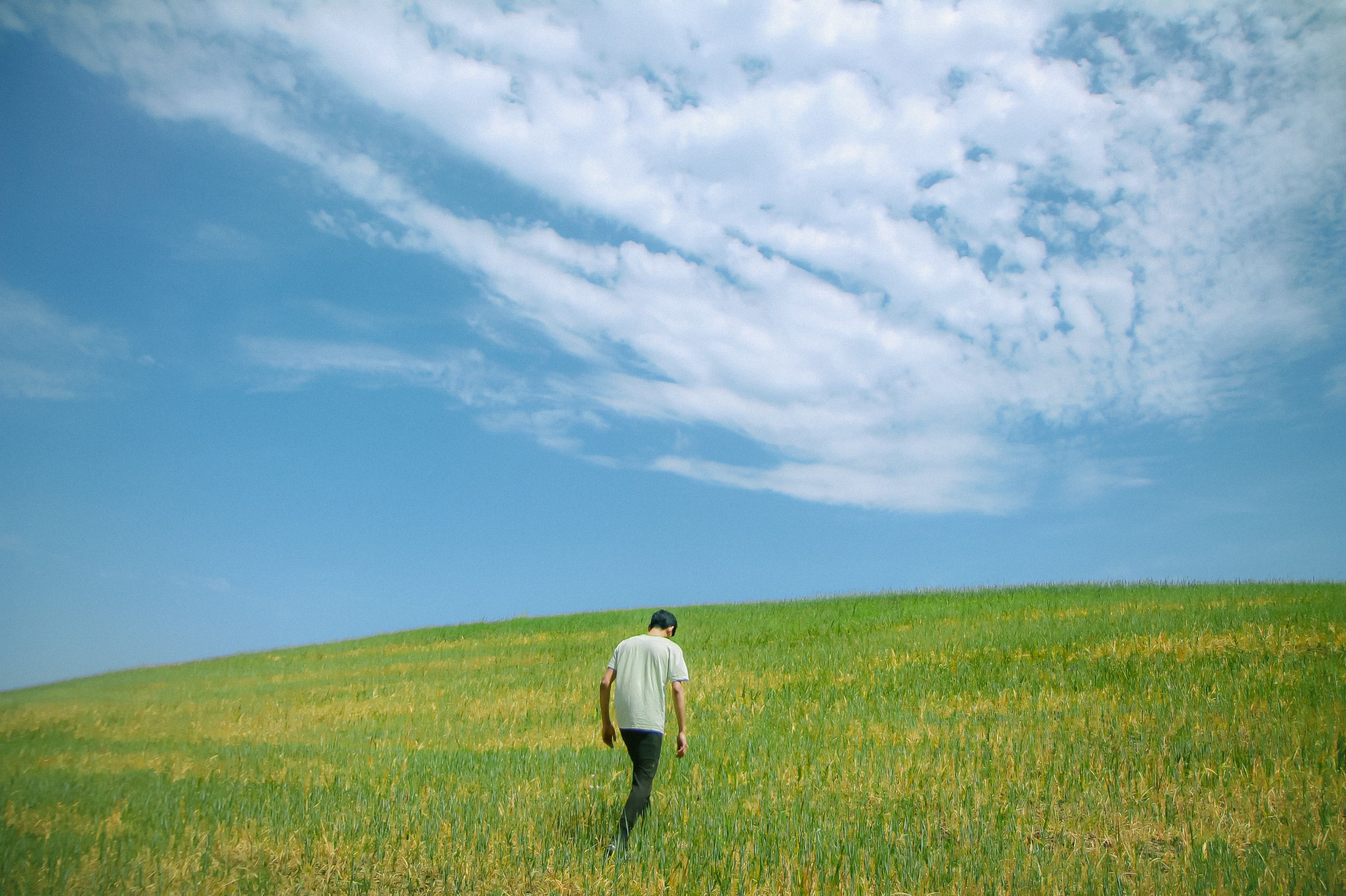 Man Walking on Grassland · Free Stock Photo