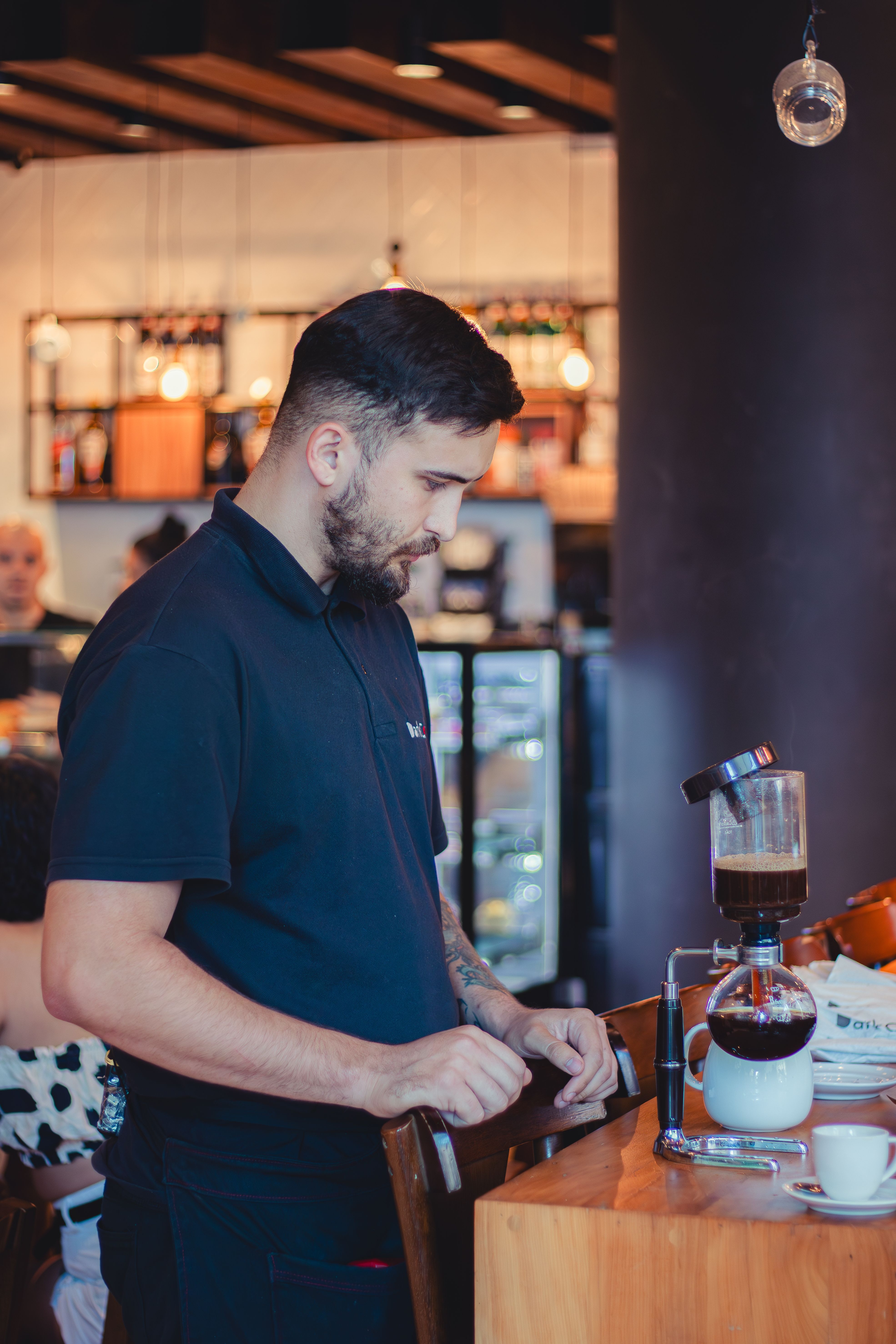 Side View of a Barista Preparing Coffee · Free Stock Photo