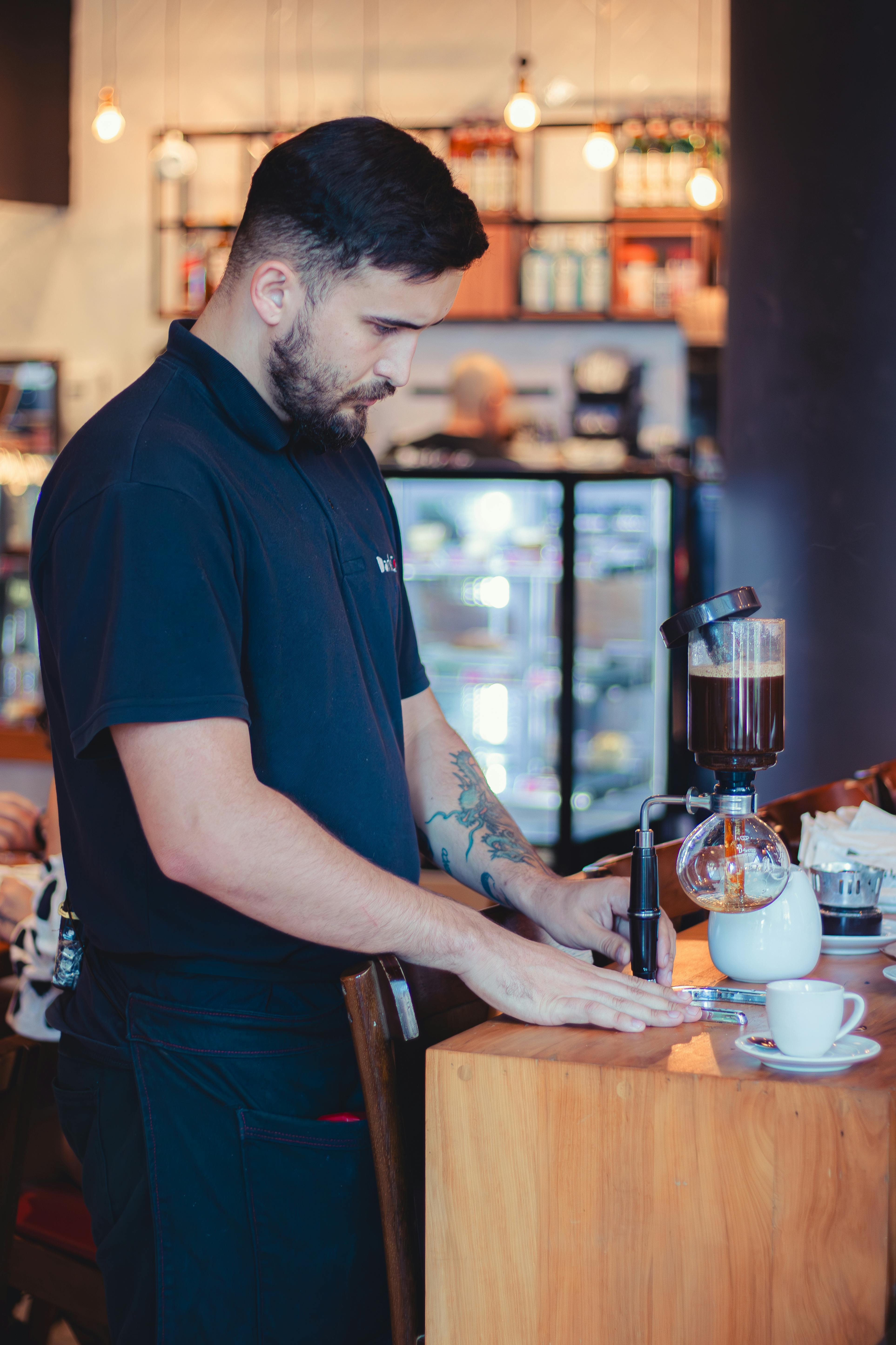 A Fine Looking Barista Holding Paper Cups while Looking Afar · Free ...