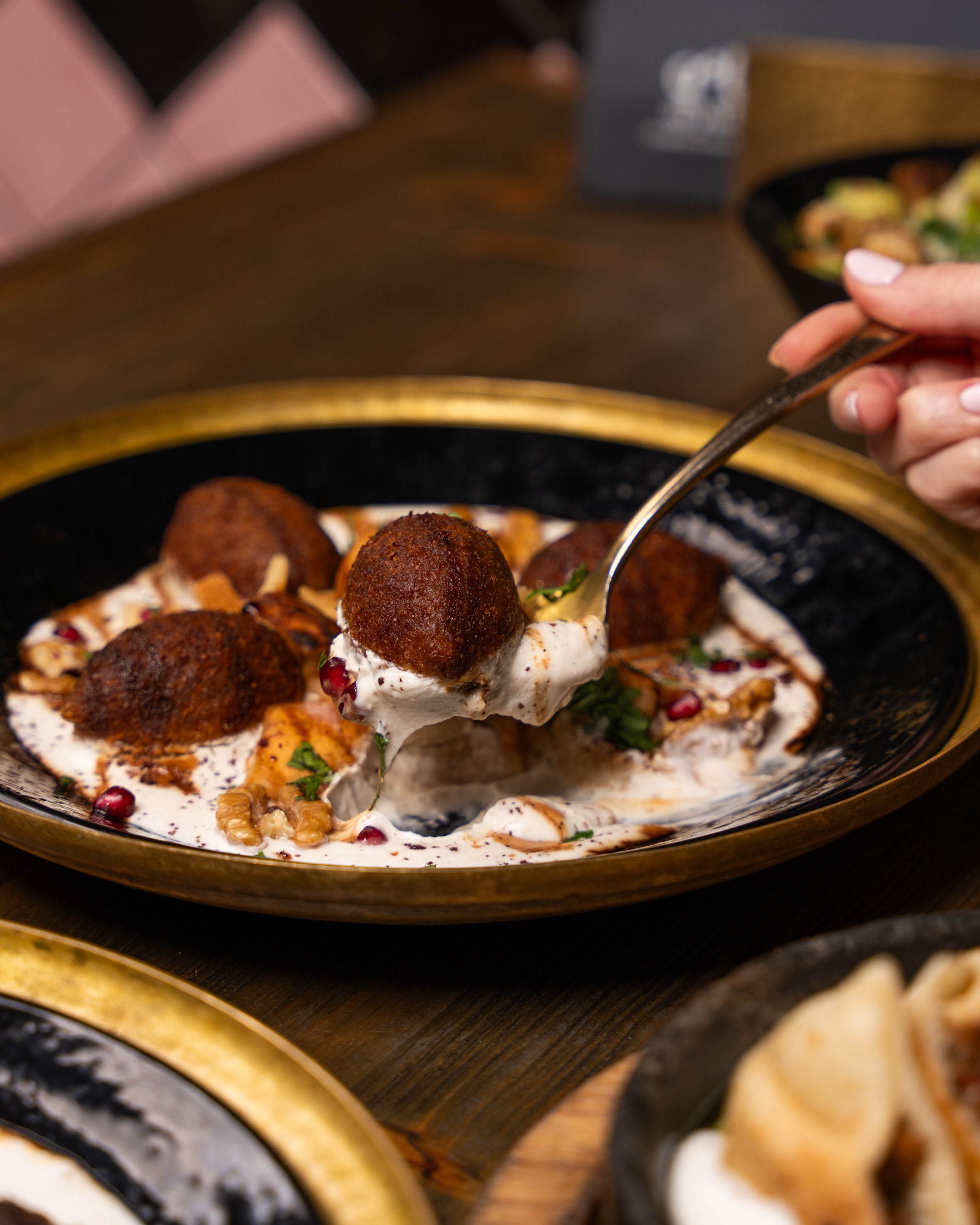 A person eating food from a plate with a spoon · Free Stock Photo