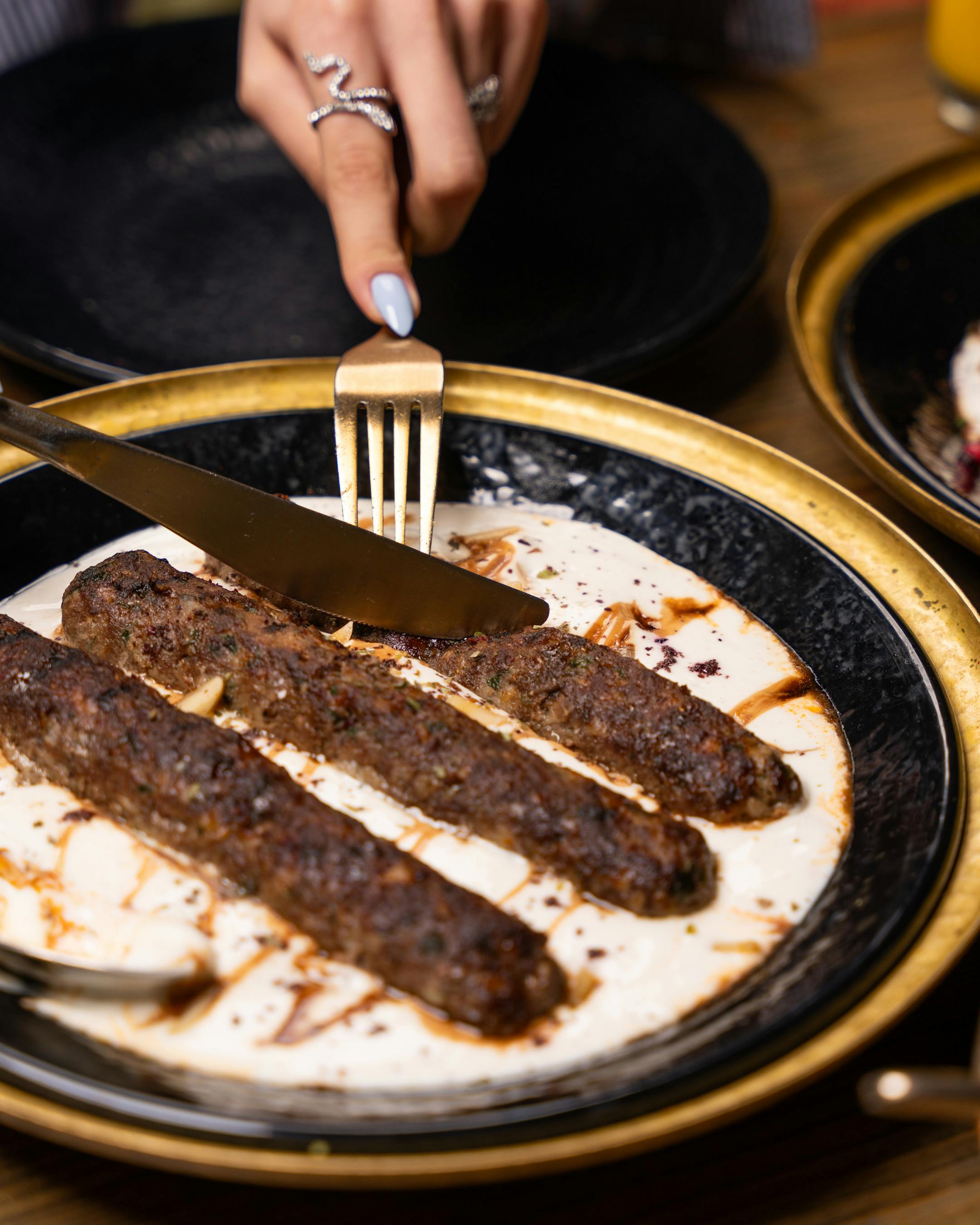 Woman Fingers Holding Fork over Plate with Meal · Free Stock Photo
