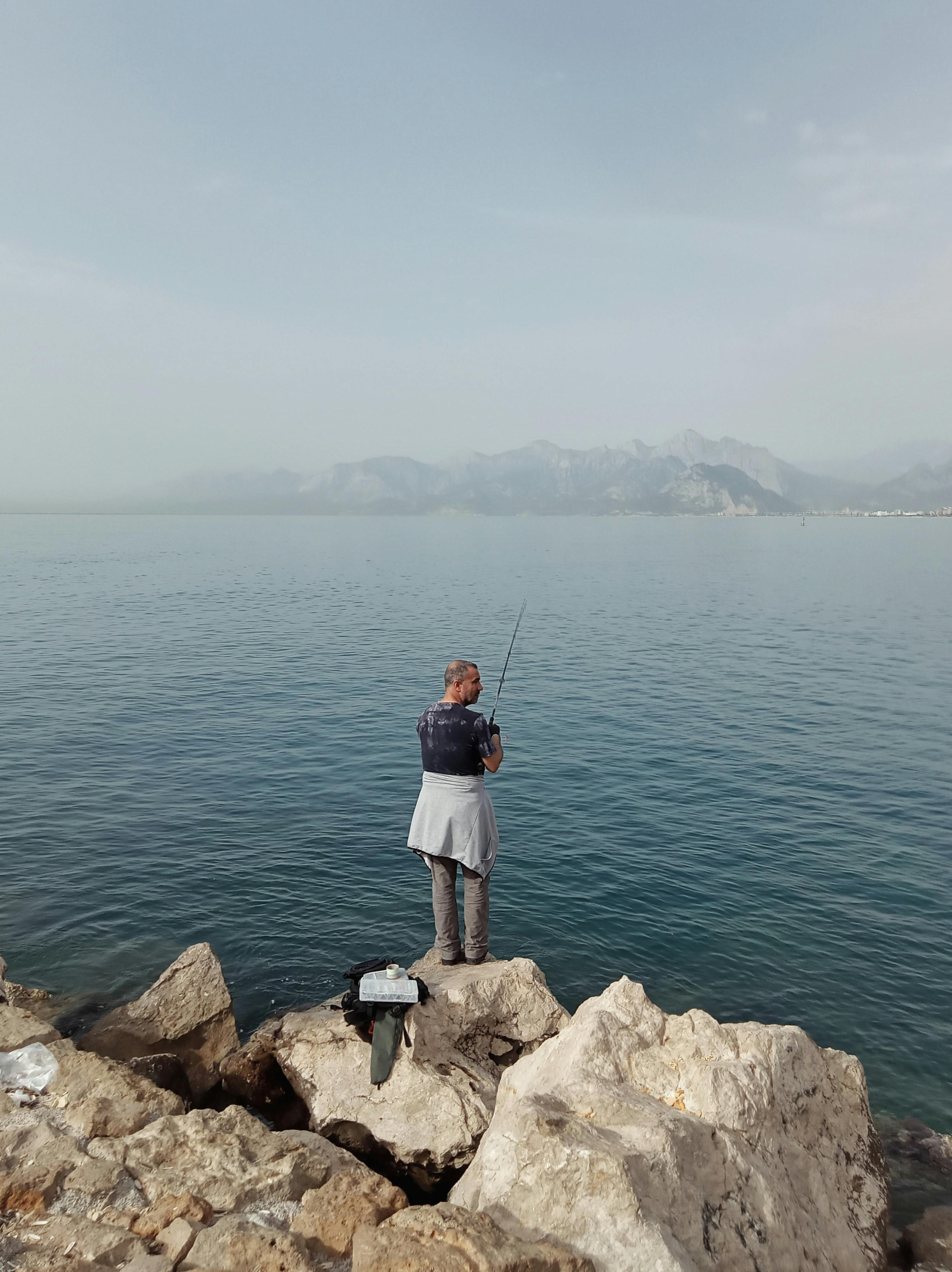 Back View of a Man Fishing from a Shore · Free Stock Photo