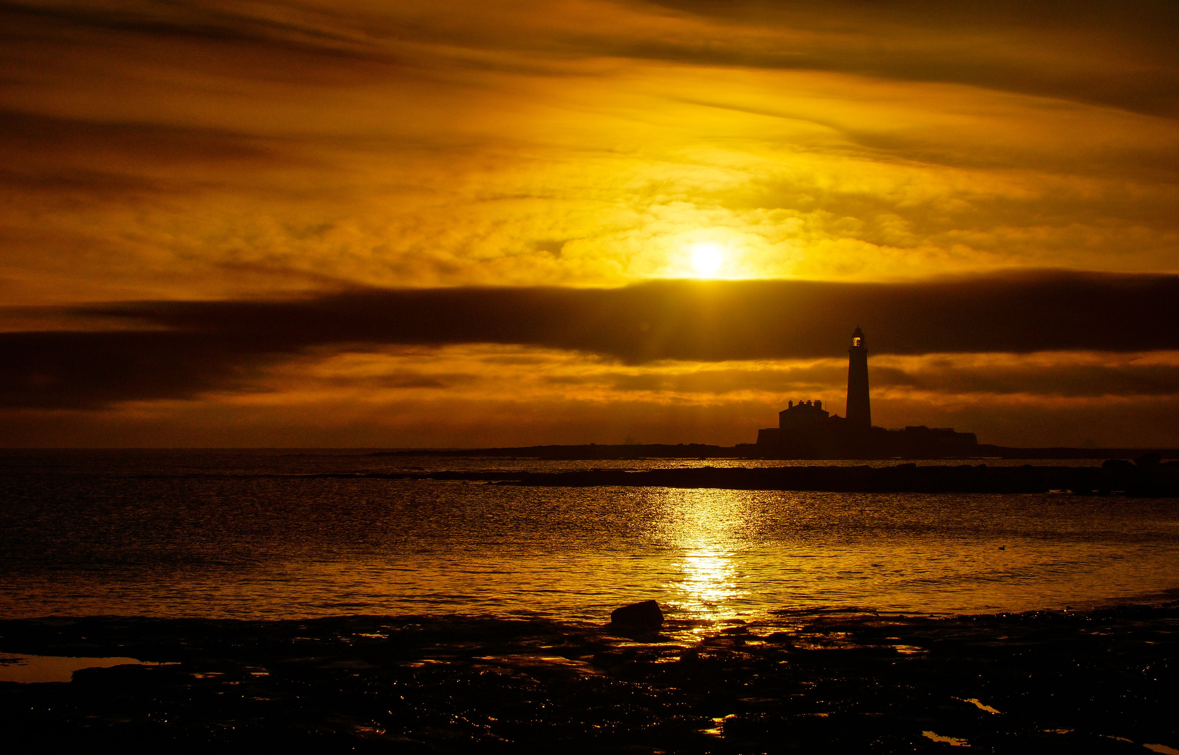 Lighthouse on an Island Against Sunset · Free Stock Photo
