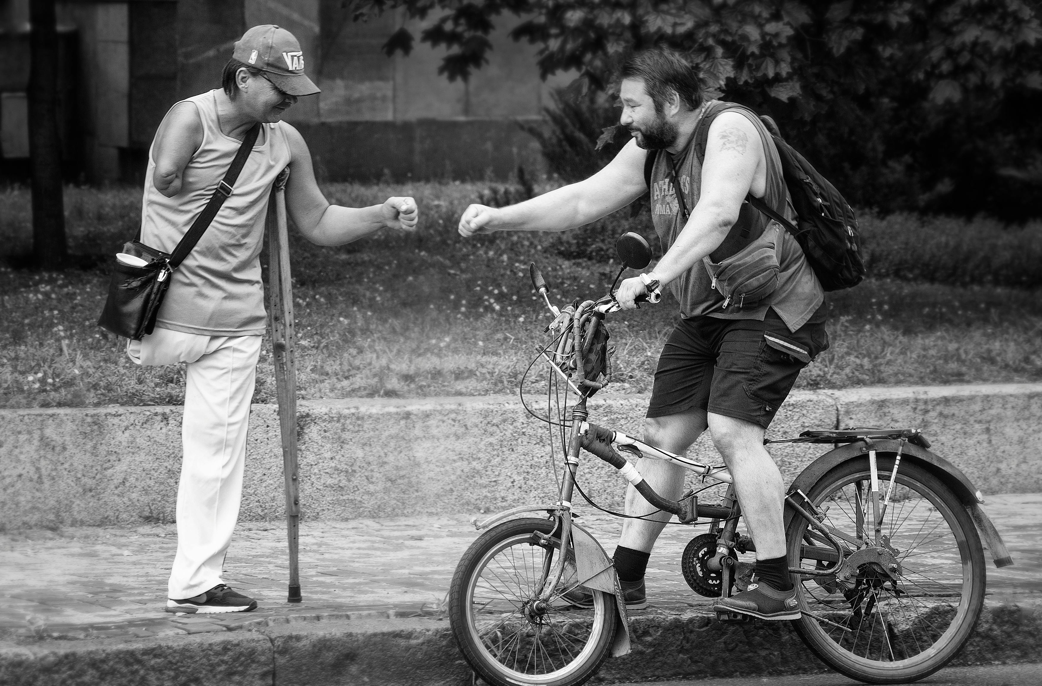 Two men shaking hands while one is on a bicycle · Free Stock Photo