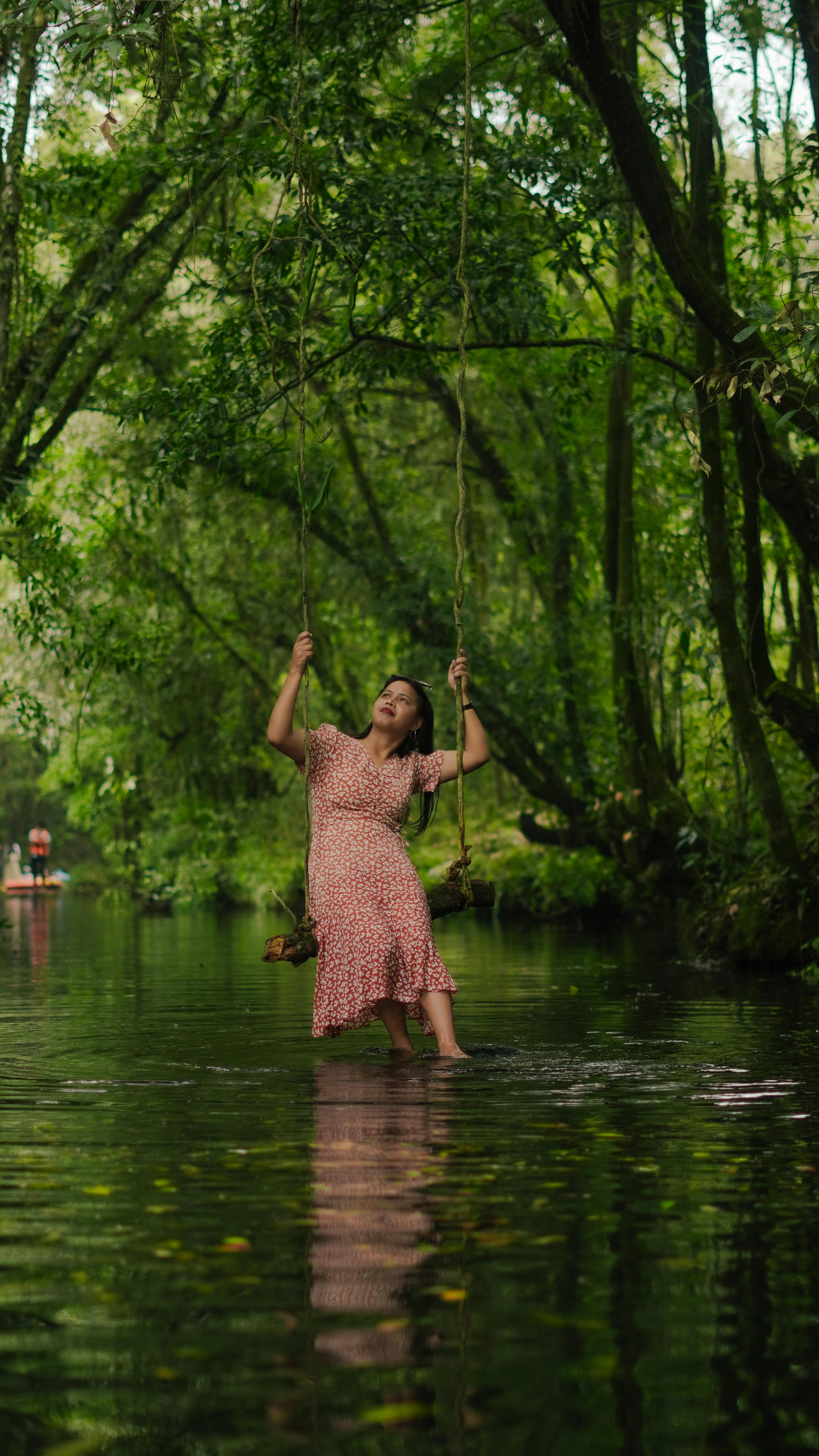 Woman Swinging over River in Forest · Free Stock Photo