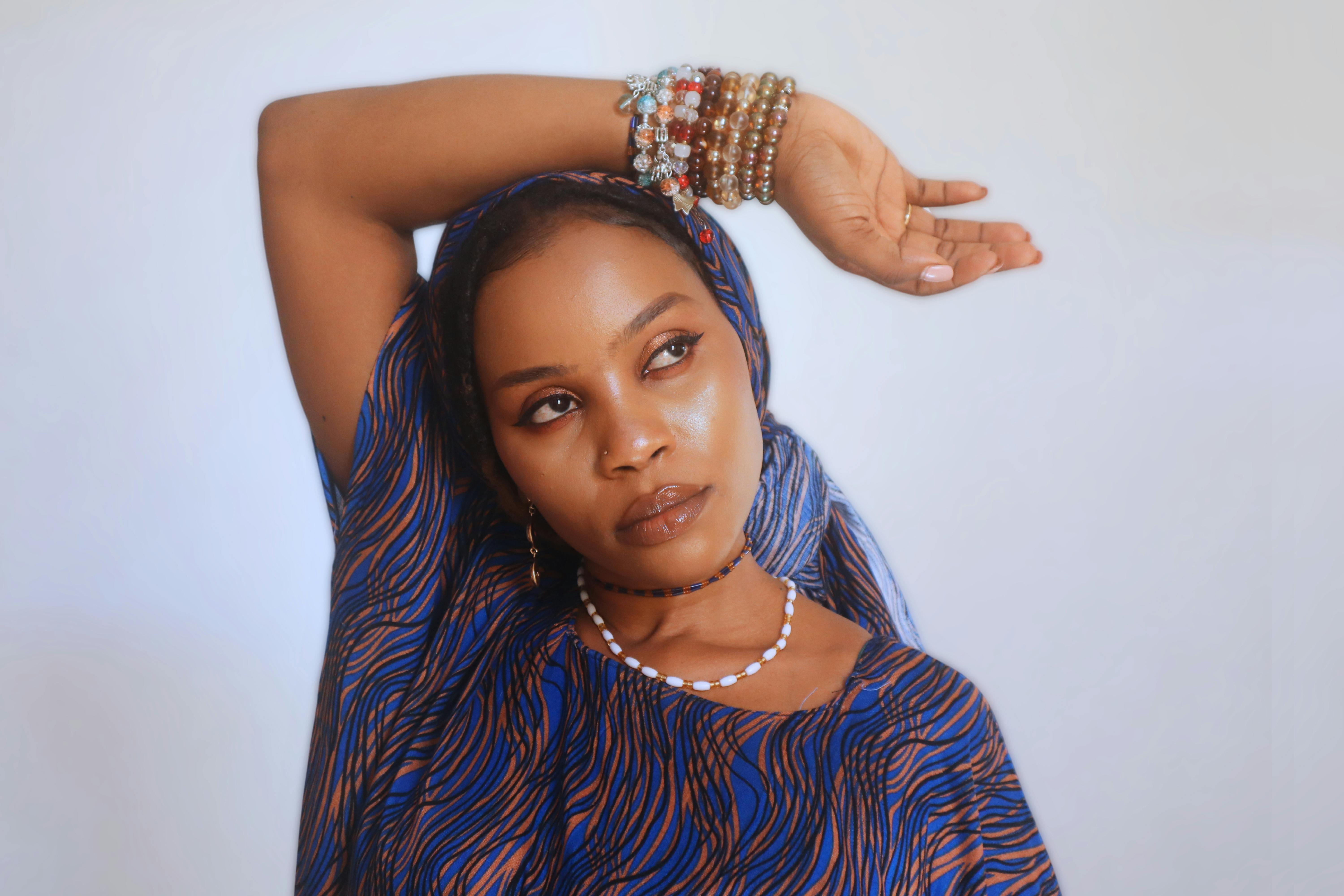 Studio Shot of a Young Woman Wearing a Patterned Dress and Bracelets · Free Stock Photo
