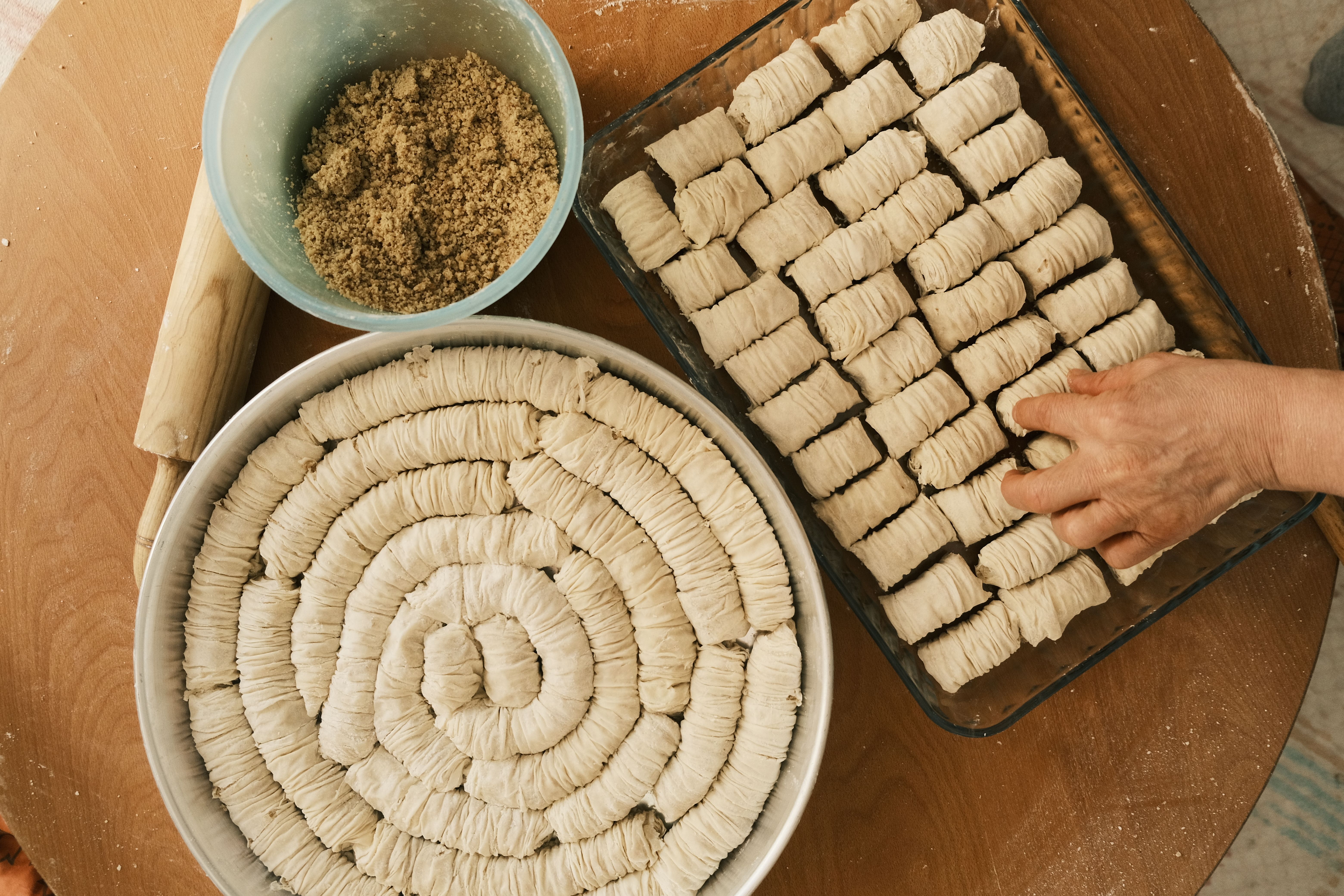 Hand over Tray and Bowls with Rolled Dough · Free Stock Photo