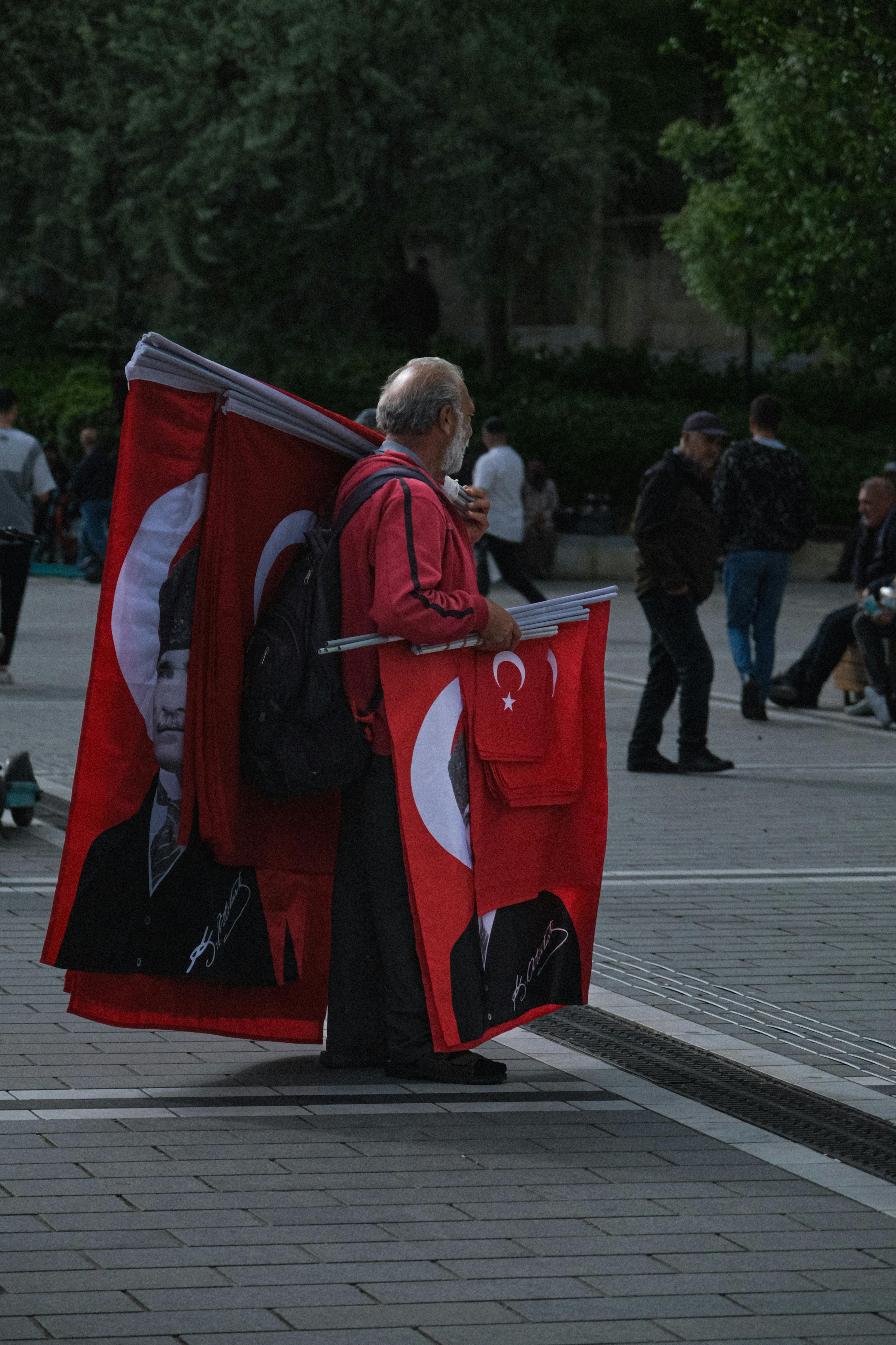 Elderly Man Holding a Bunch of Flags on a Street · Free Stock Photo