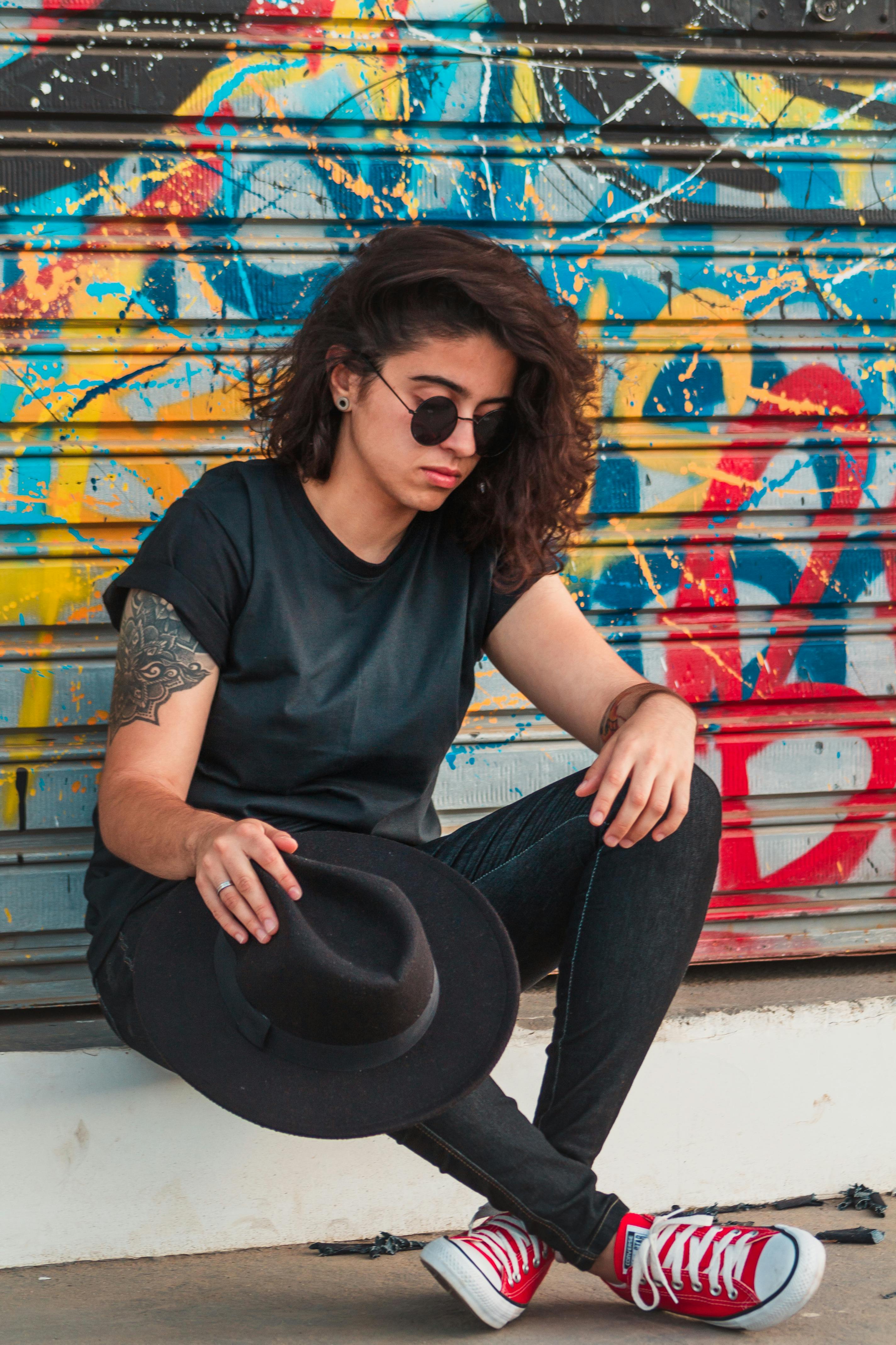Woman Sitting Under Roller Shutter Background · Free Stock Photo