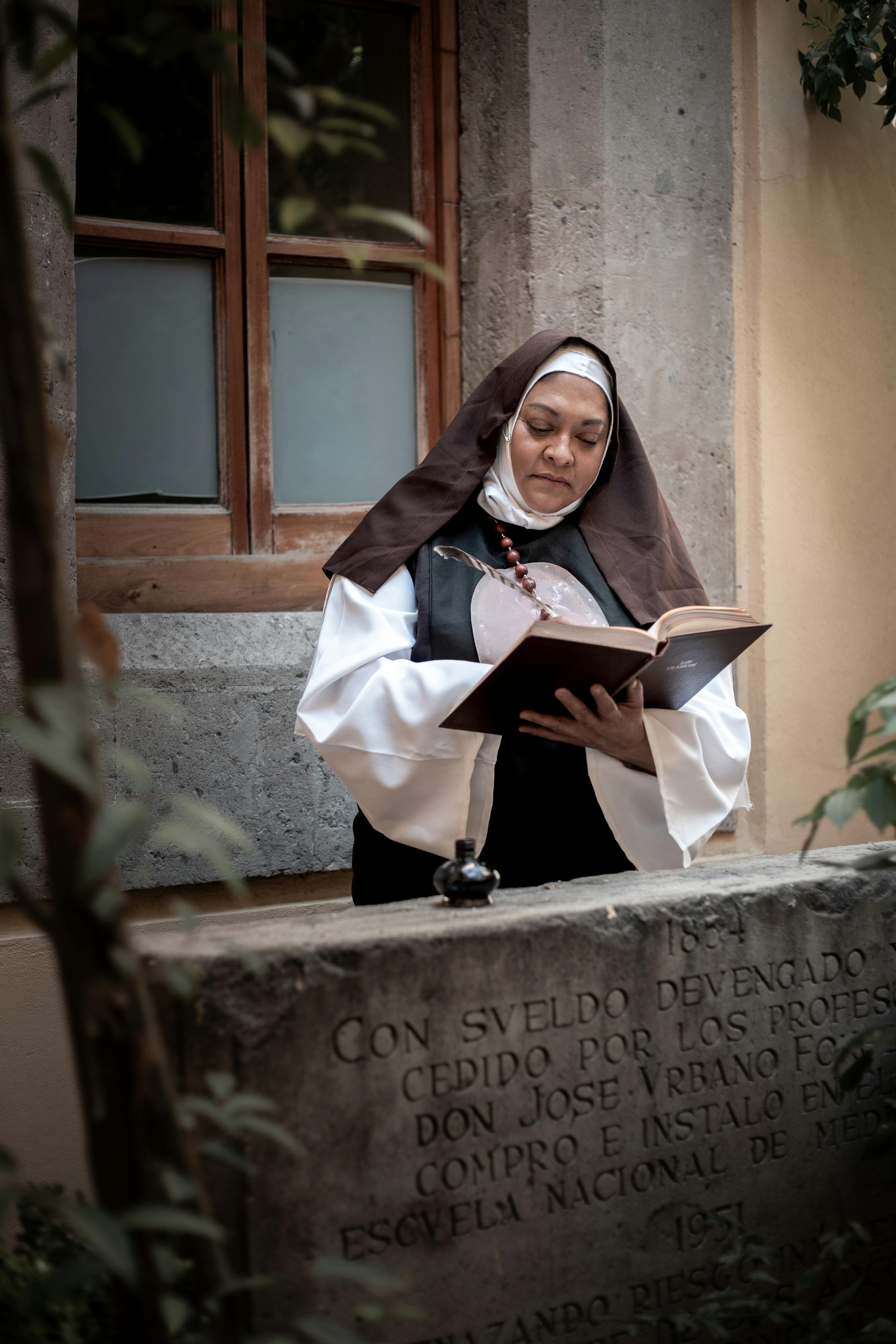 A Nun Writing in a Notebook with a Quill · Free Stock Photo