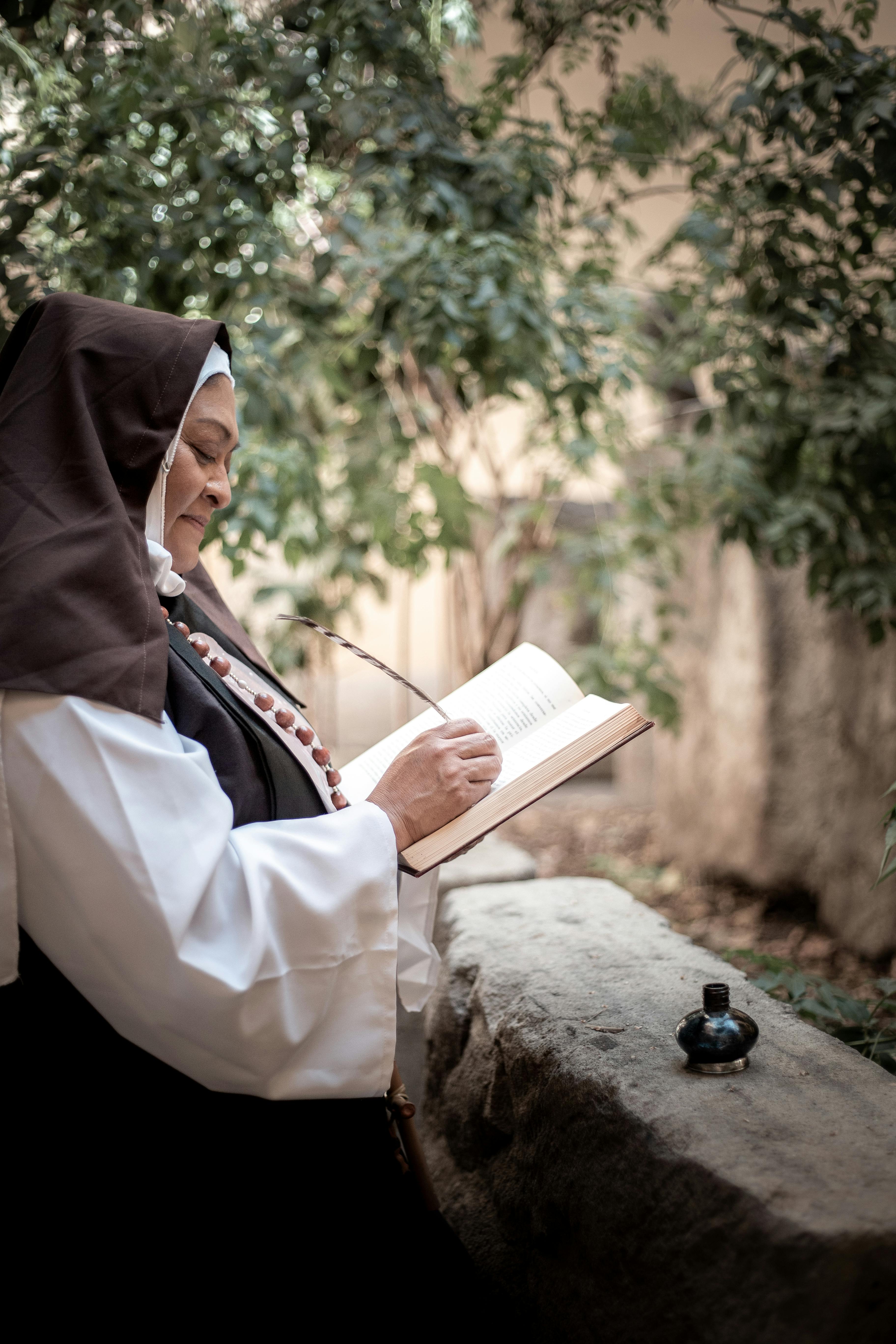 Nun Writing with Ink and Feather · Free Stock Photo
